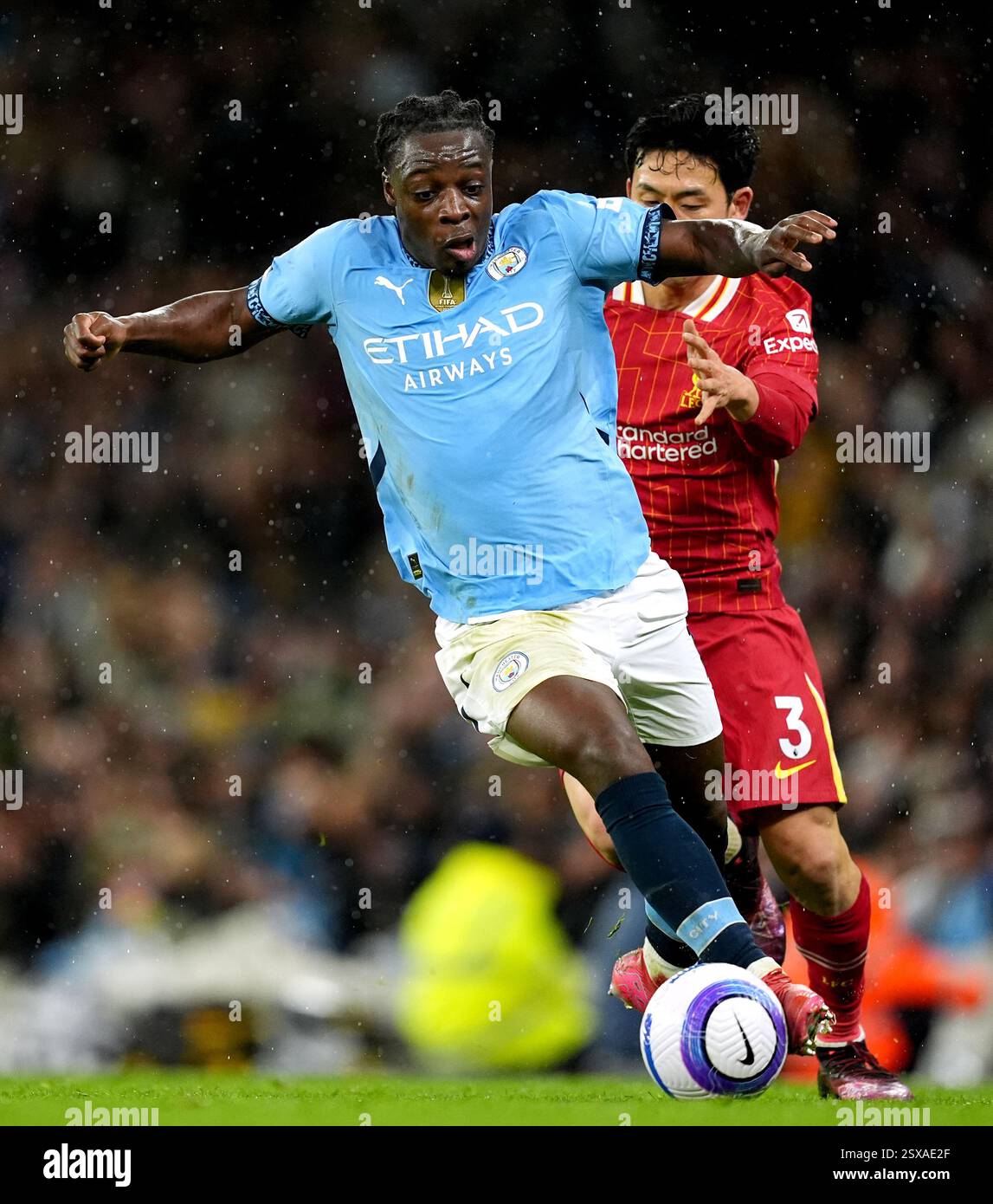 Manchester City's Jeremy Doku battle for the ball with Liverpool's Wataru Endo during the ...