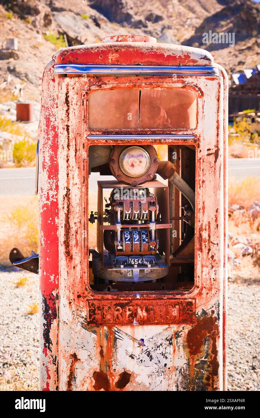Red and white gas station with a broken window. The inside of the gas station is rusted and ...