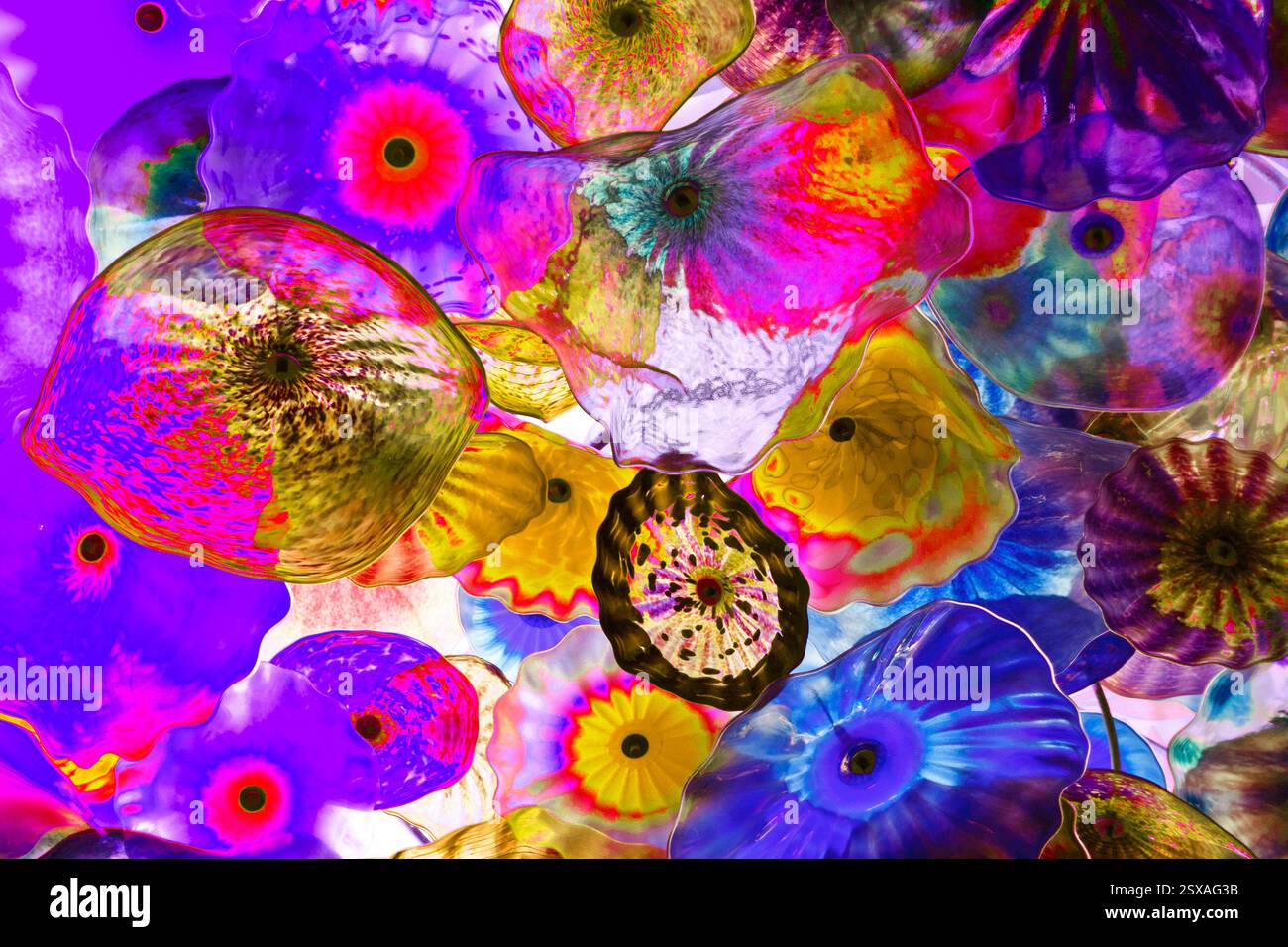 Colorful array of glass flowers with a bright blue flower in the center ...