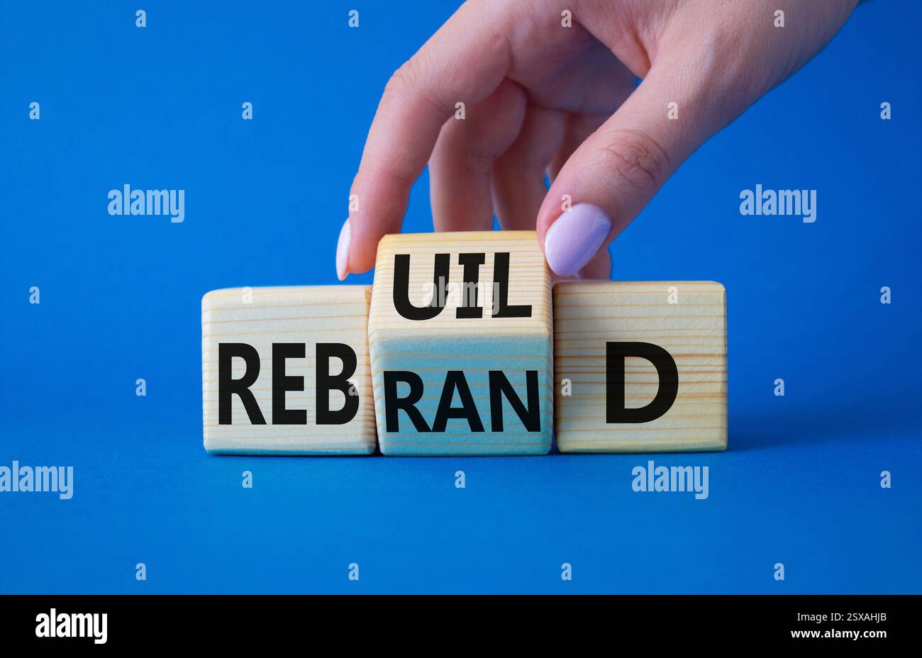 Rebuild and Rebrand symbol. Businessman hand turns wooden cubes and ...