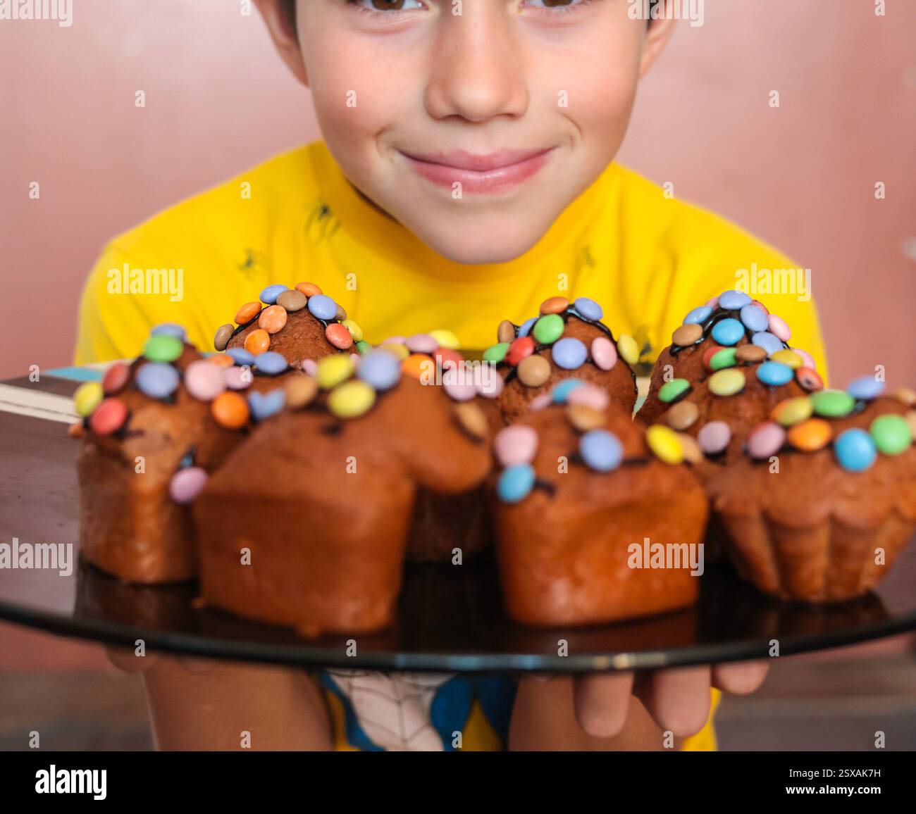 Boy holding a tray of hand-baked Easter cupcakes decorated with colorful candies Stock Photo - Alamy