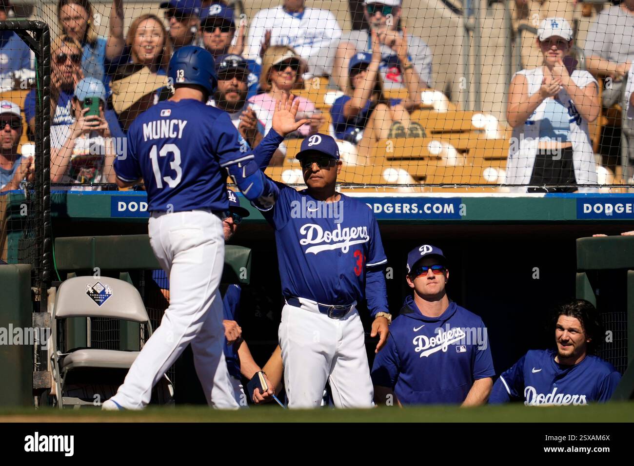 Los Angeles Dodgers' Max Muncy (13) returns to the dugout after hitting ...