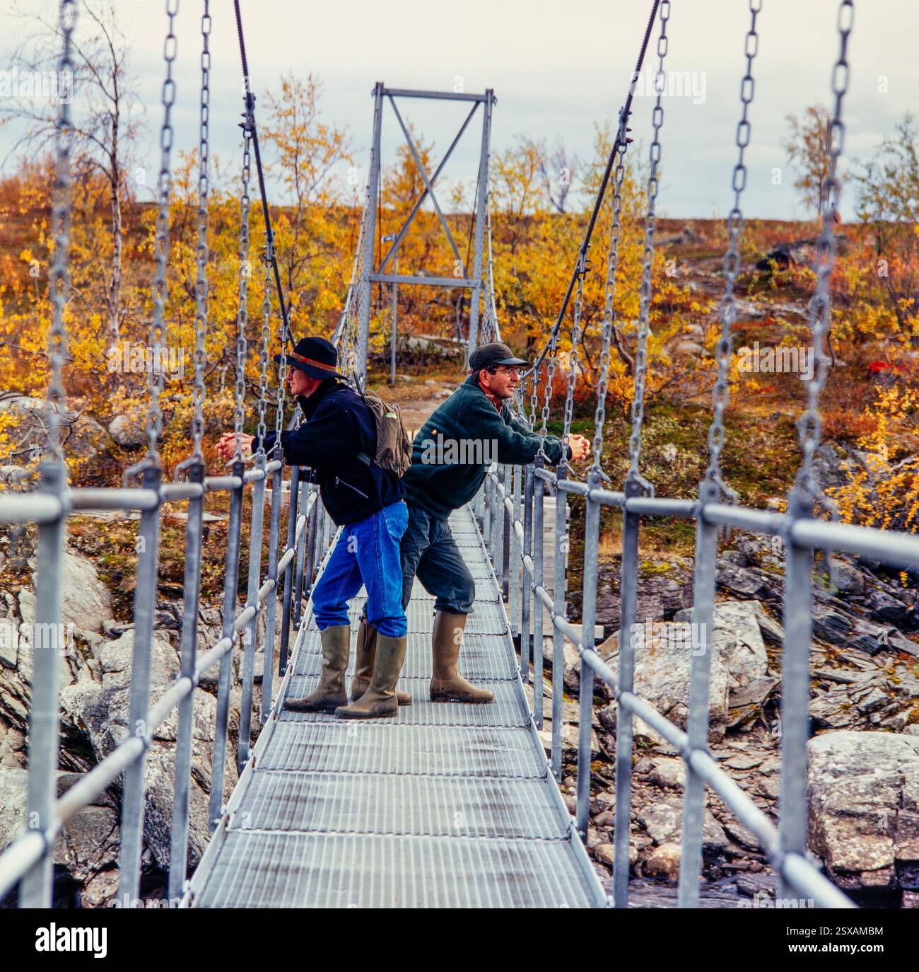 Hikers on suspension bridge Stock Photo - Alamy