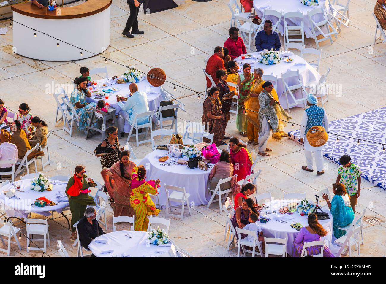Indian wedding reception with elegantly dressed guests enjoying dinner ...