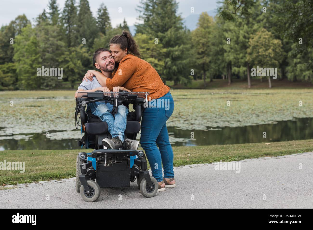 Man, an electric wheelchair user in the warm embrace of his wife, a ...