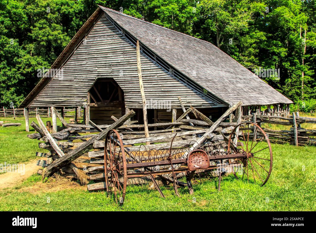 Barn with a wheelbarrow in front of it. The wheelbarrow is old and ...