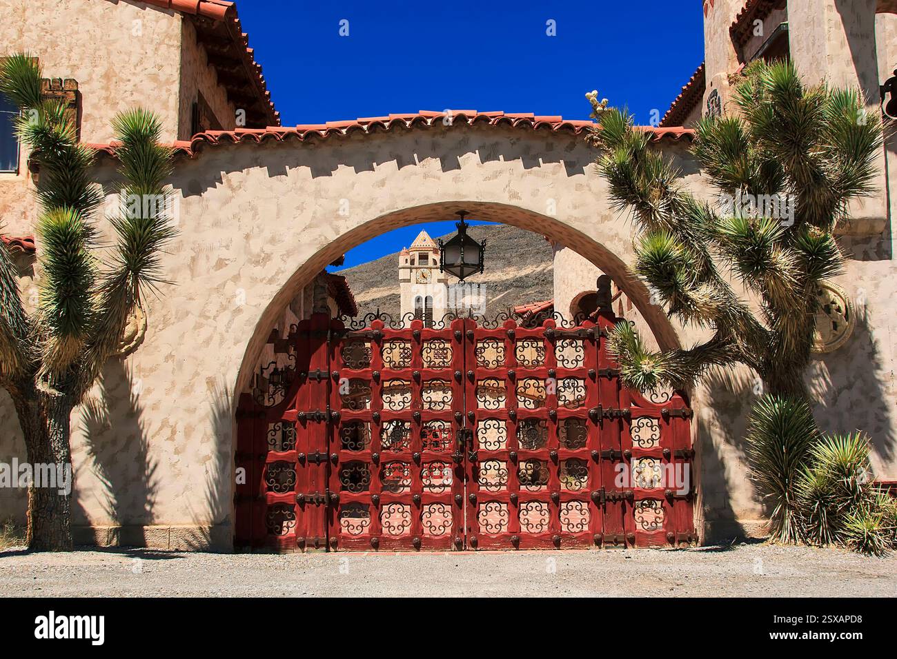 Red gate with a stone archway. The gate is open and the archway is ...