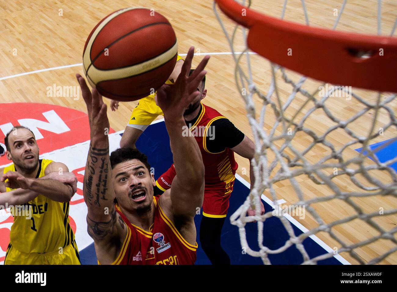 250223 Jonah Radebaugh of Montenegro grabs the ball in front of Denzel ...