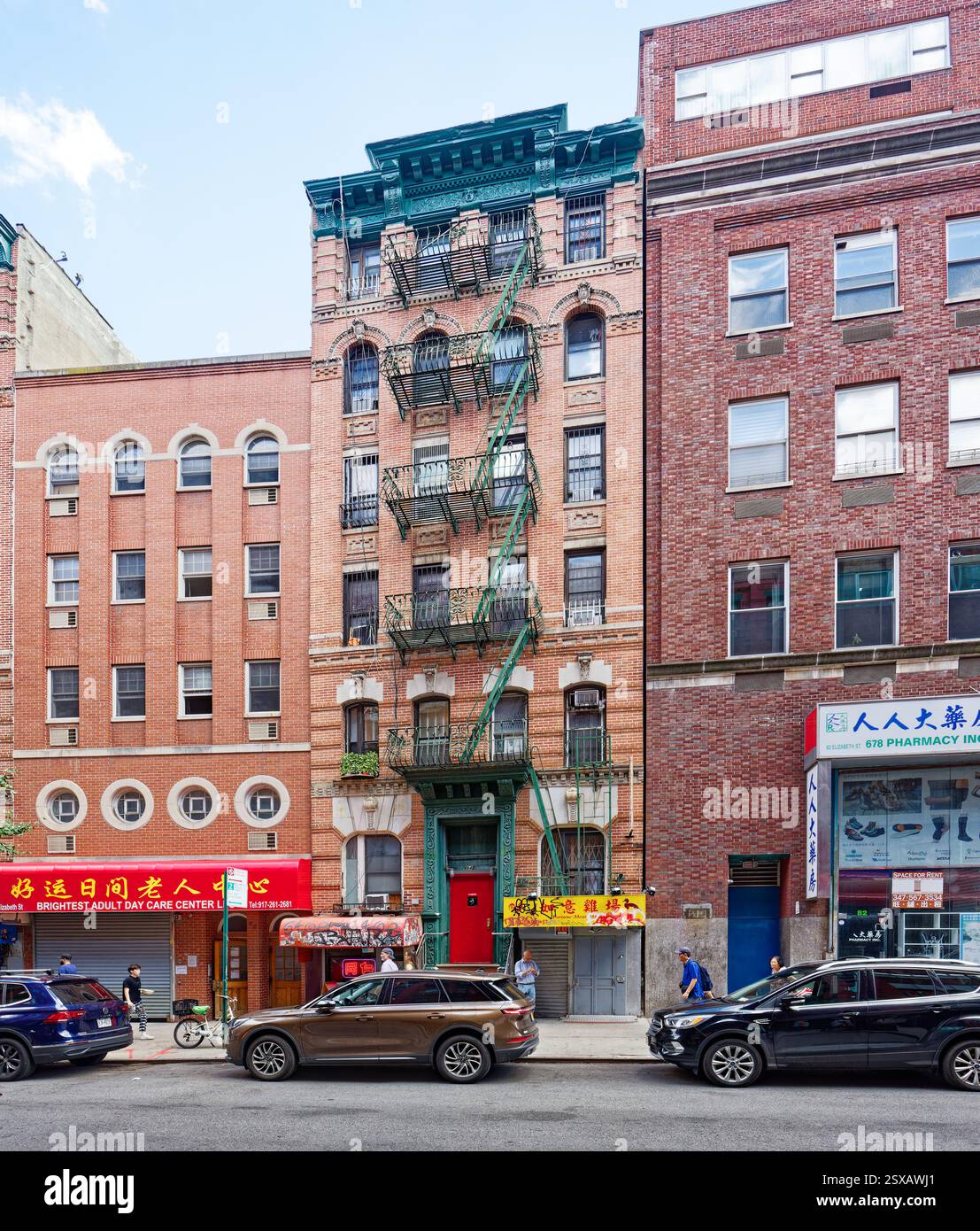 A stamped metal cornice crowns 84 Elizabeth Street, a seven-story brick ...