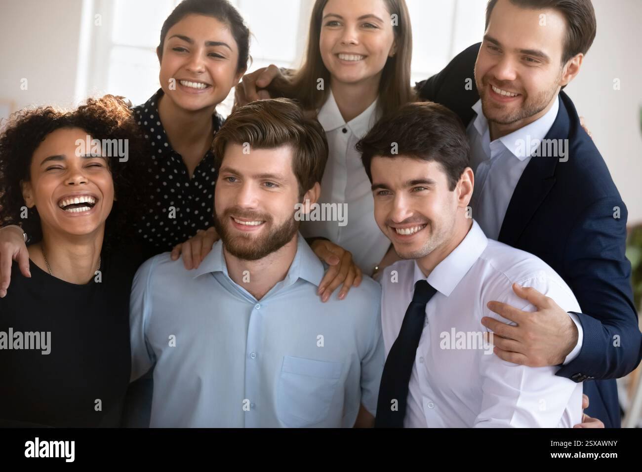 Group of young attractive workmates, multiethnic team members hugging ...