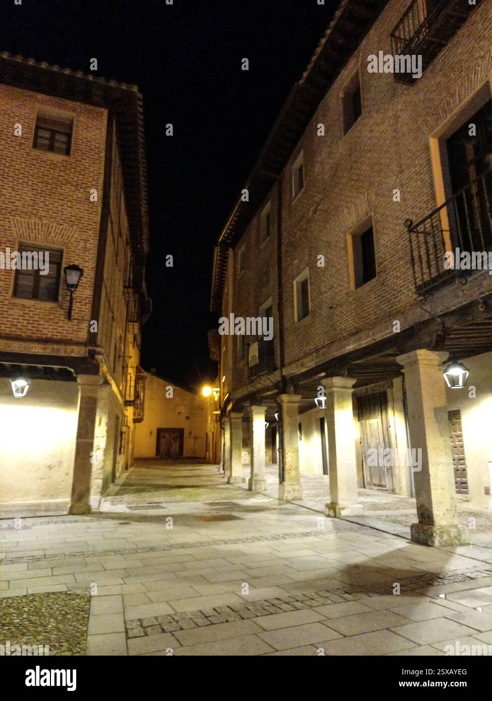 A peaceful nighttime view of a historic street in Burgo de Osma, Spain ...