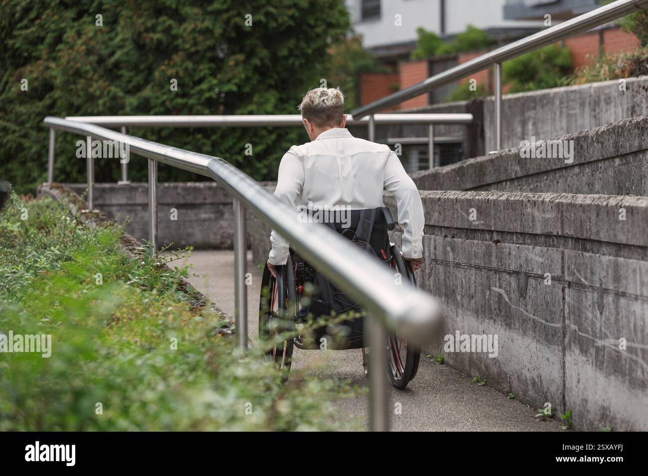 Person with physical disability moving in a manual wheelchair along the ...