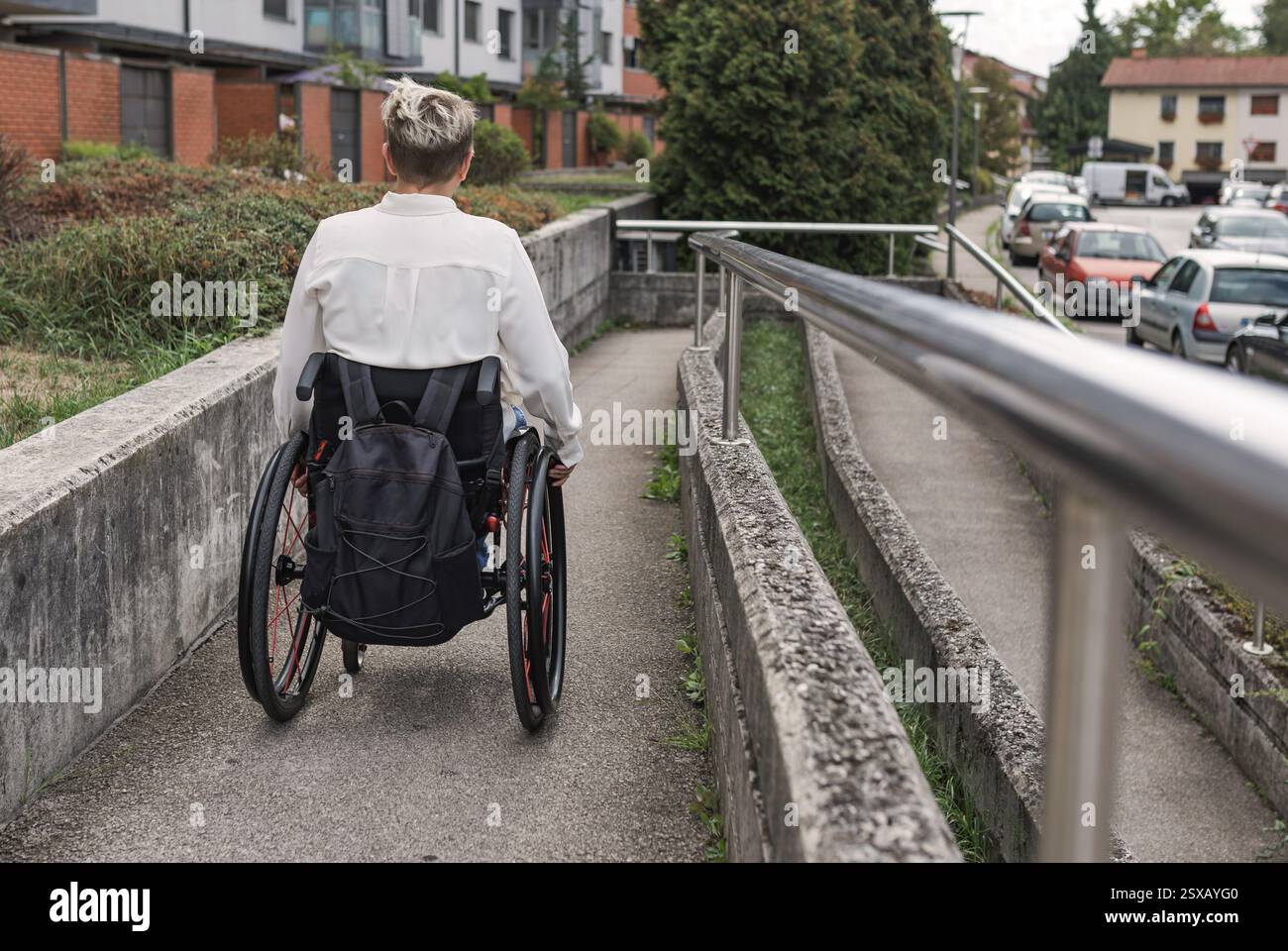 Person with physical disability moving in a manual wheelchair along the ...
