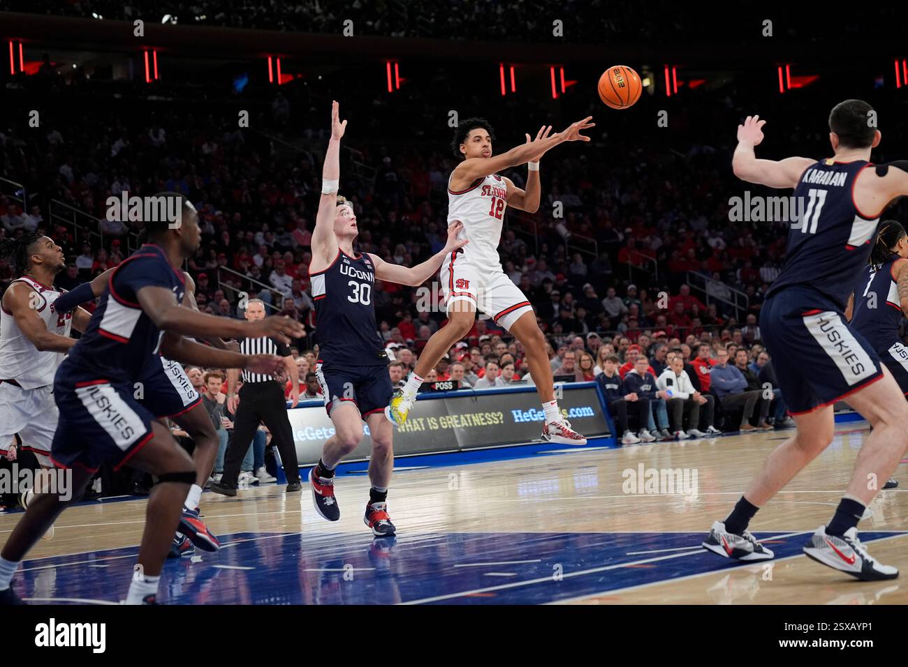 St. John's RJ Luis Jr., center, passes the ball against UConn defenders ...