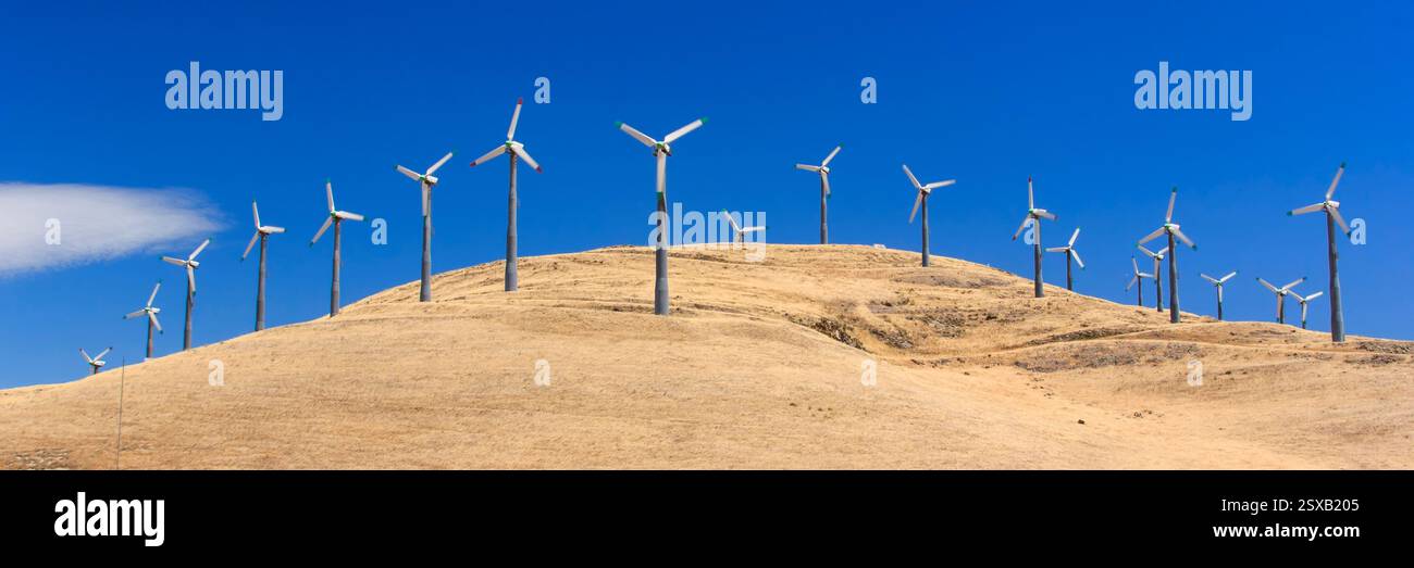 Large group of wind turbines are on a hill. The wind turbines are all ...