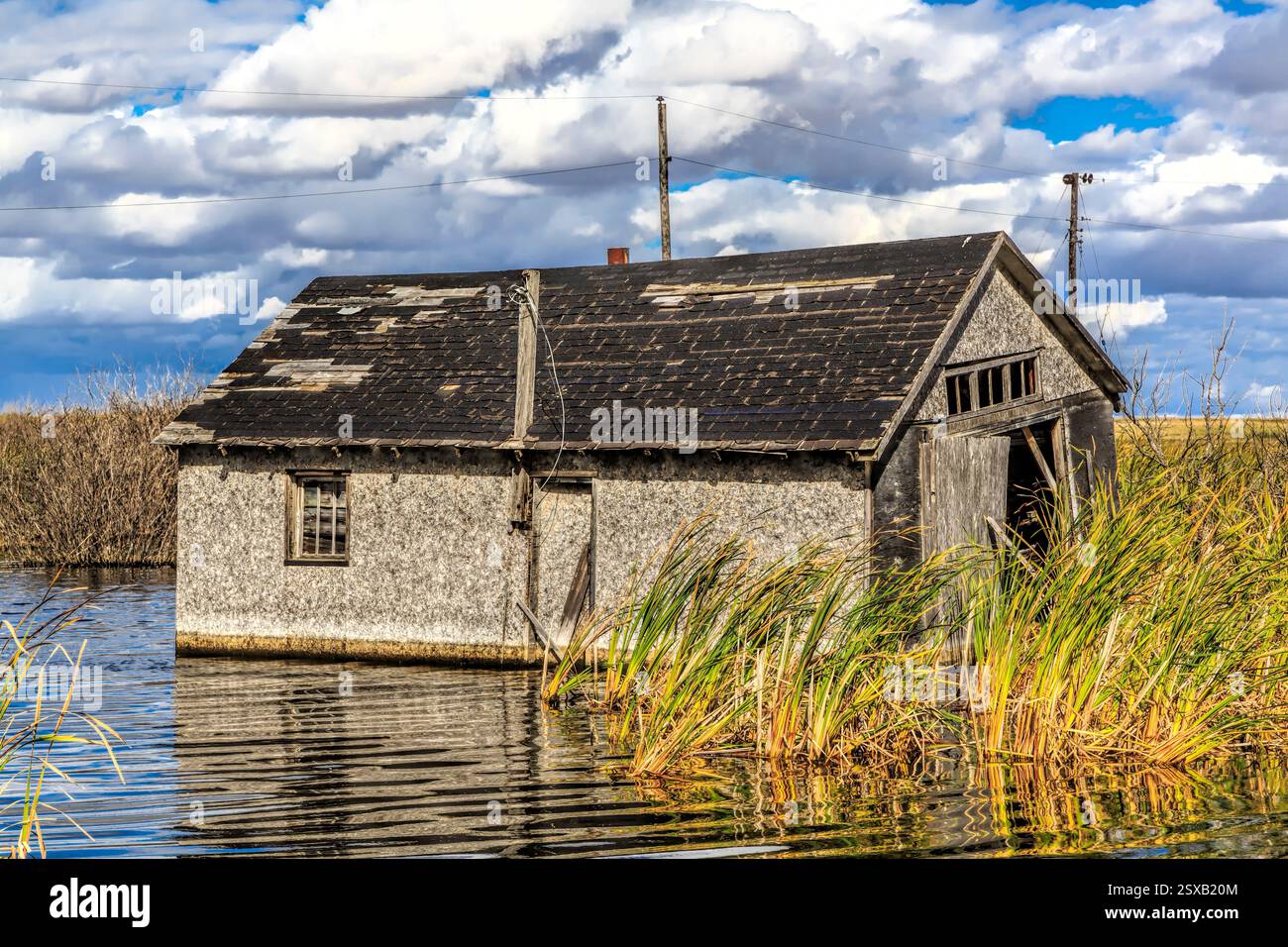 Small house is floating in a body of water. The house is old and has a ...