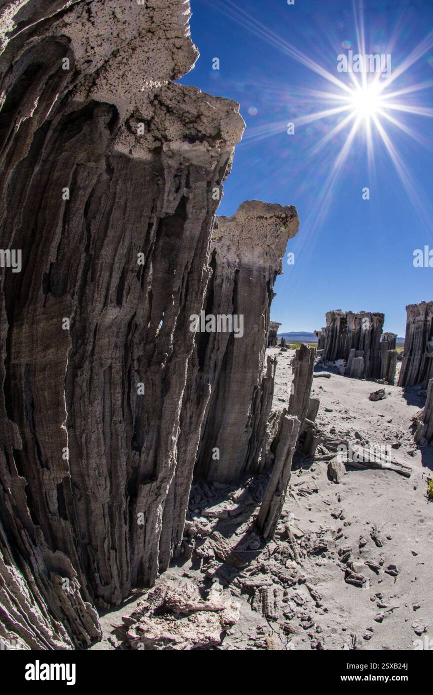 Rock formation with a sun shining on it. The sun is in the sky and is ...