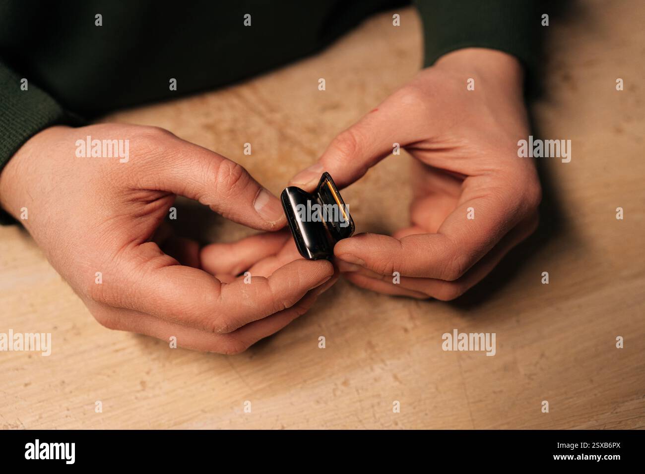 Top view of technician carefully replacing battery of smartwatch using ...