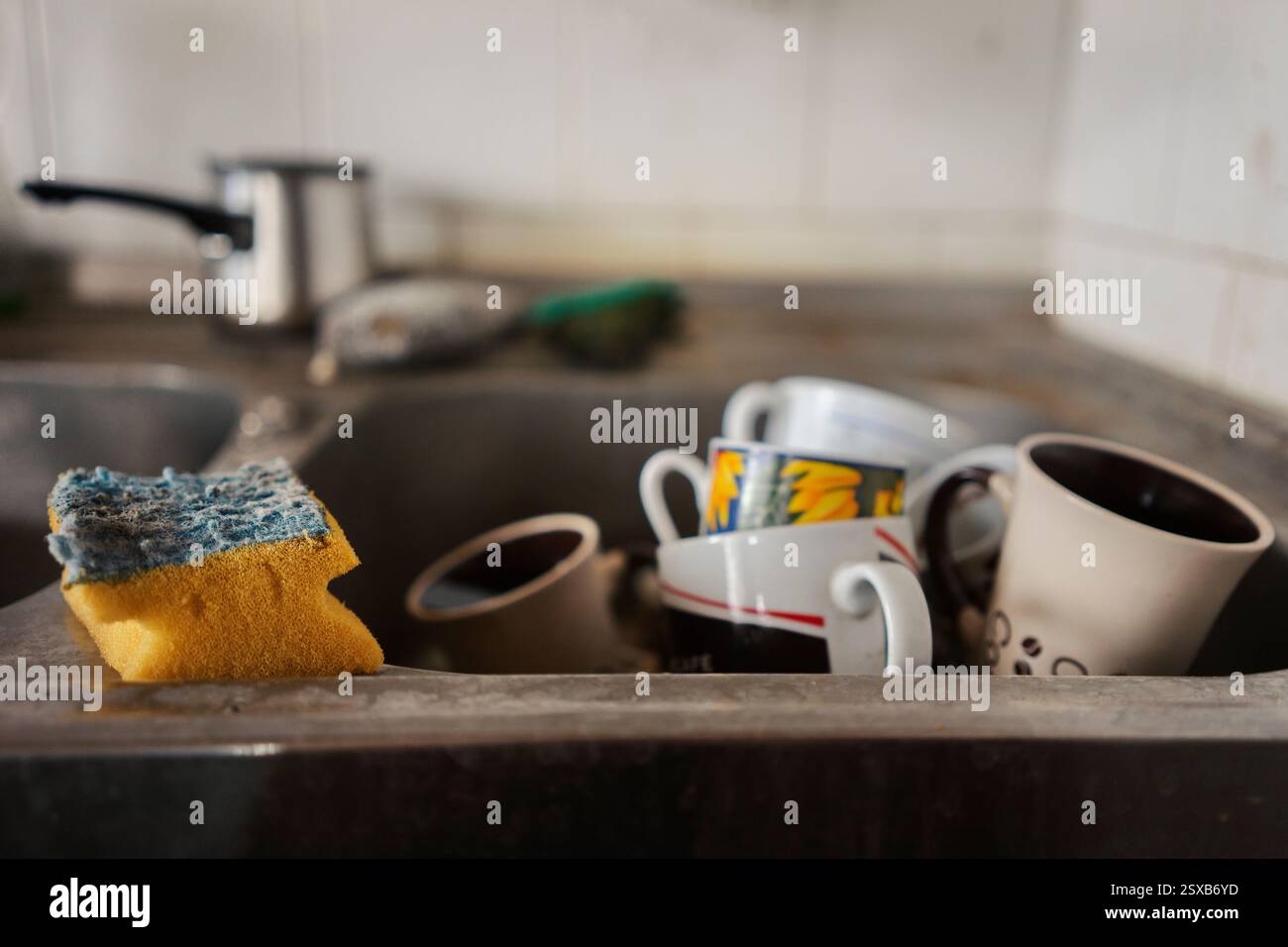 An old used kitchen sponge and a sink full of dirty dishes Stock Photo ...