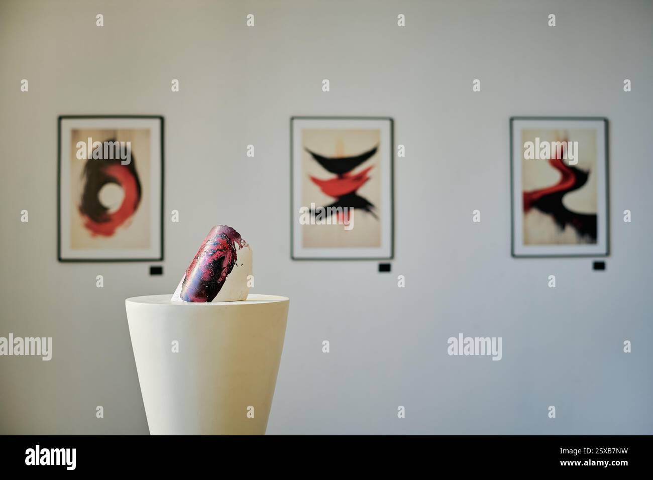 Modern art gallery featuring abstract paintings hanging on plain walls ...