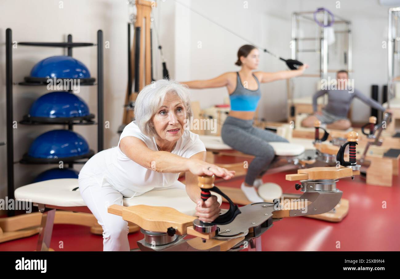 Mature woman during Pilates training performs exercises and tasks on ...