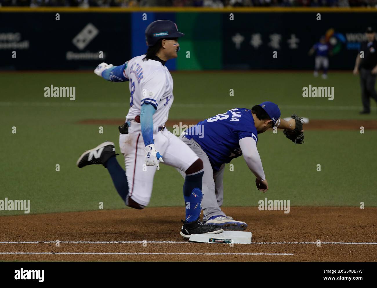 Taiwan's Yu Chang runs into first base safely during the fourth inning ...