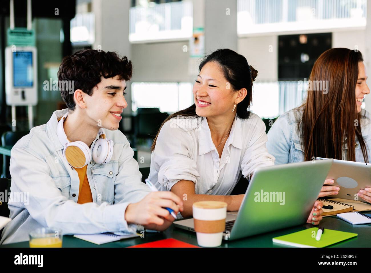 Diverse group of happy high school students studying together on campus ...