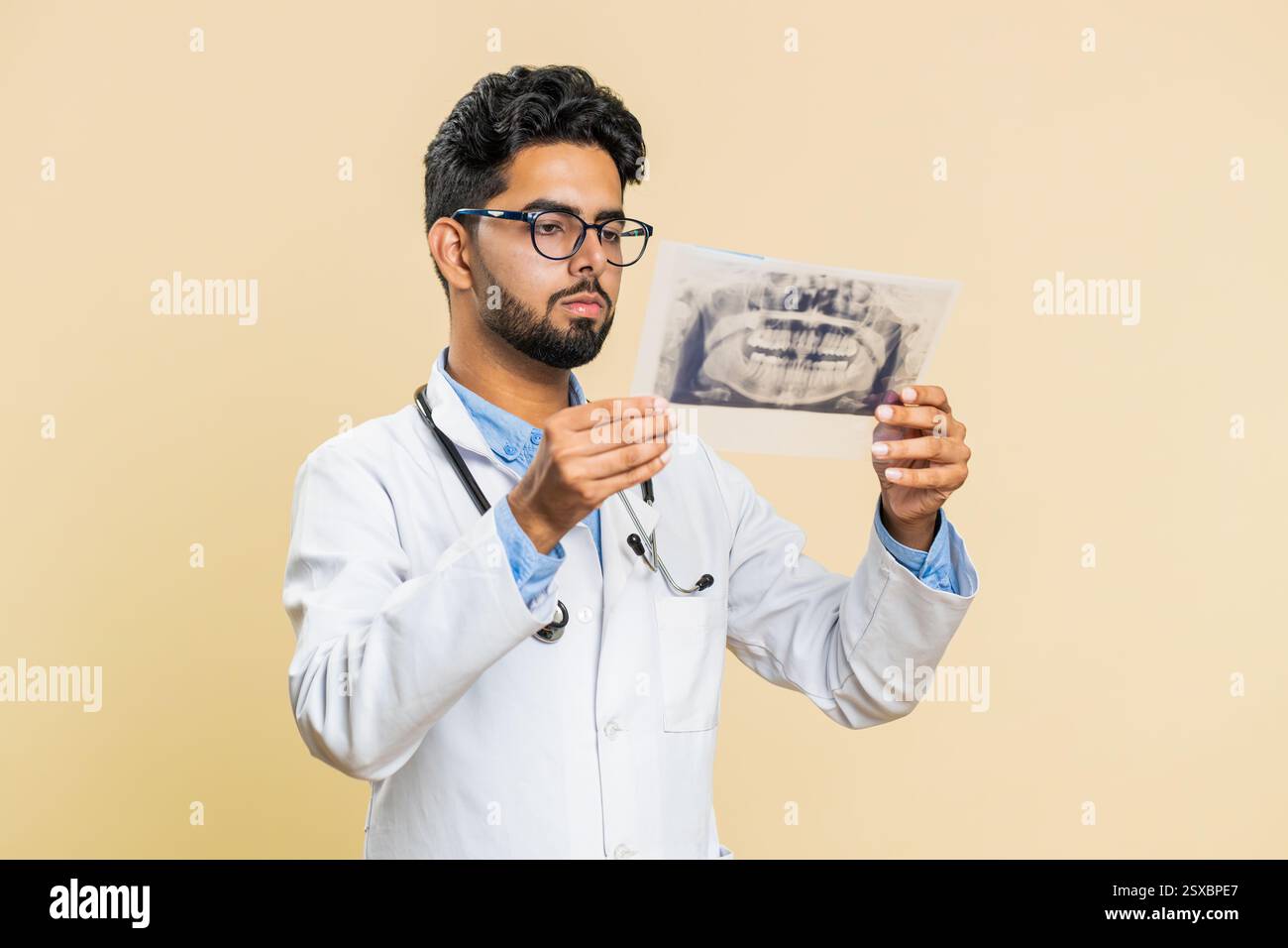 Indian young doctor orthodontist man examines a panoramic x-ray picture ...