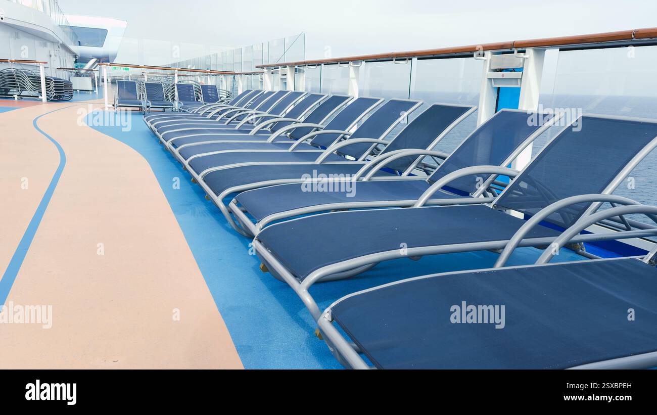 A serene view of blue deck chairs perfectly arranged in neat rows on a ...