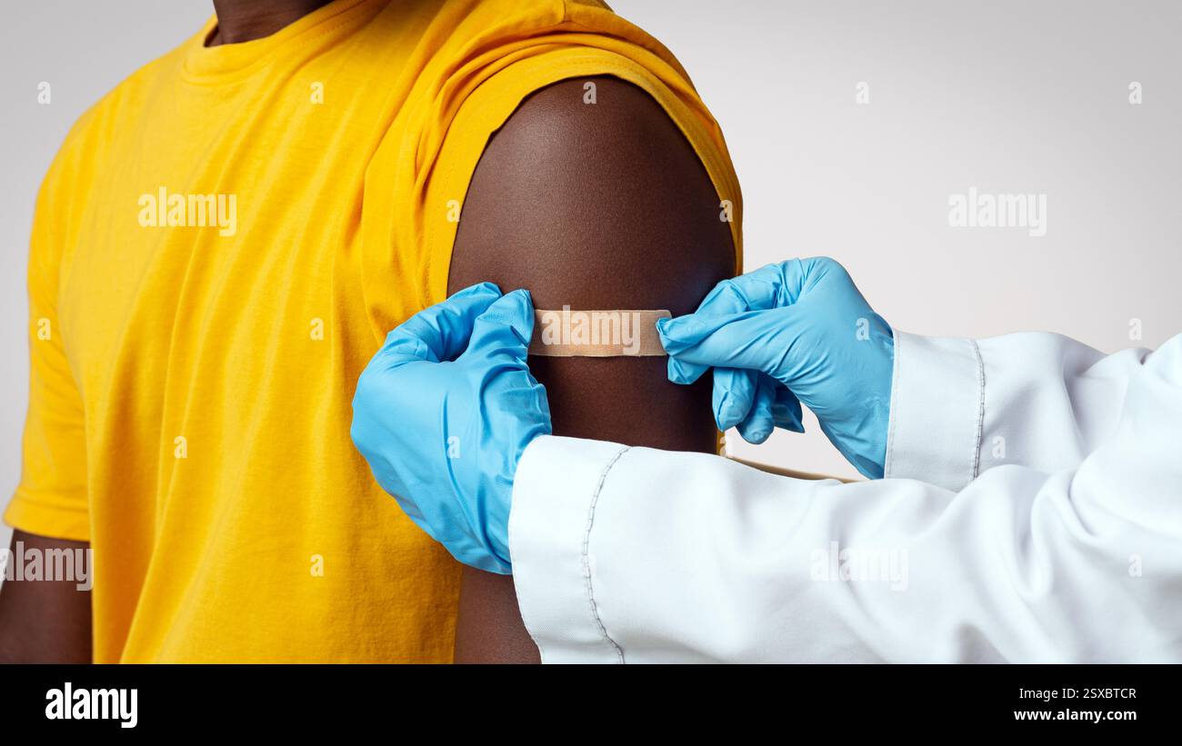 Doctor Applying Plaster On Arm Of Black Male Patient After Vaccine Shot ...