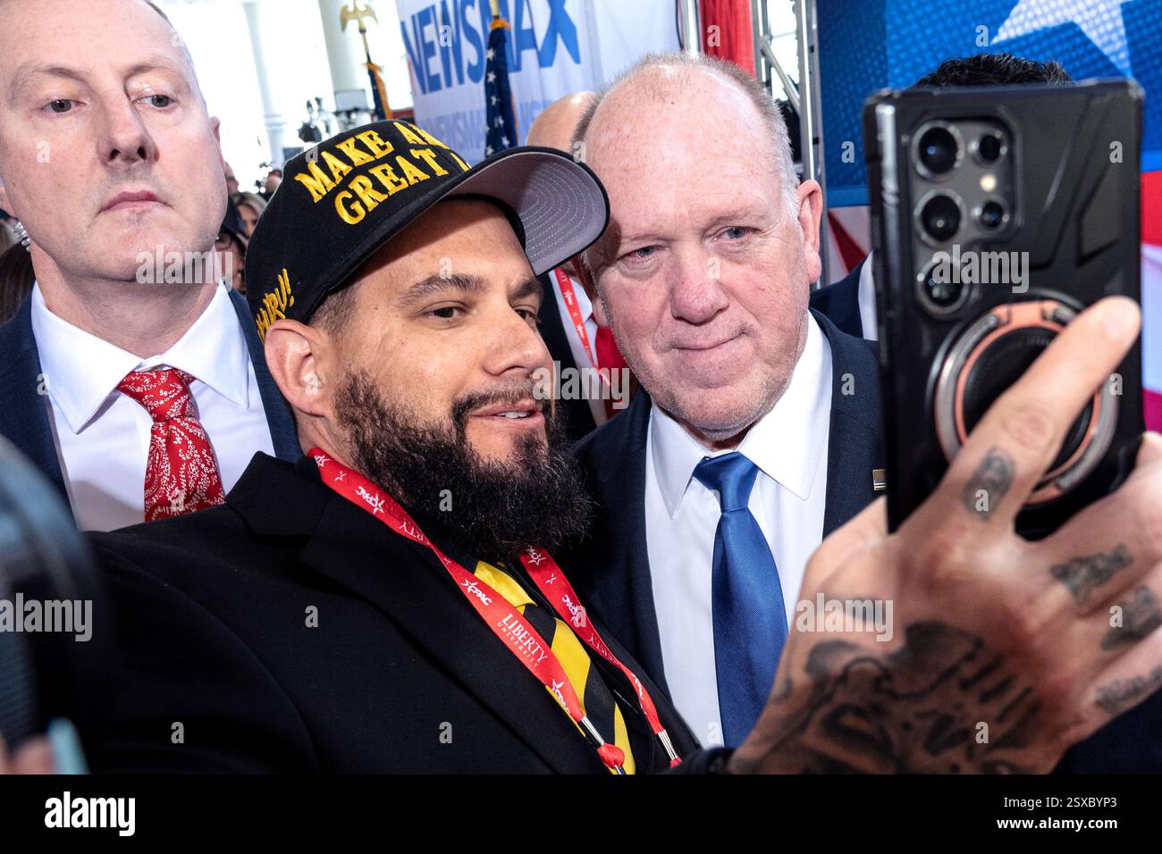Tom Homan is swarmed by media and attendees as he walks along Radio Row ...