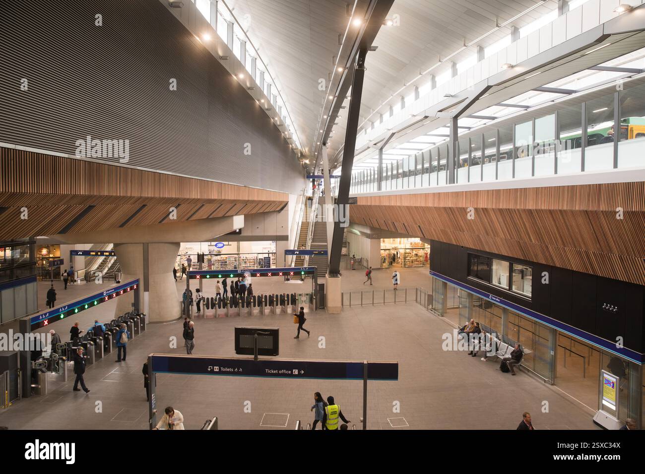 Commuters at London Bridge station. Ticket gates, shops, and train ...