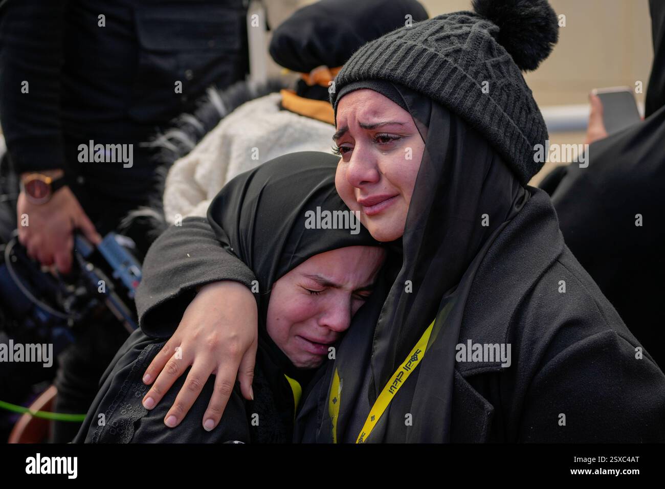 Mourners react as a trailer carrying the coffins containing the bodies ...