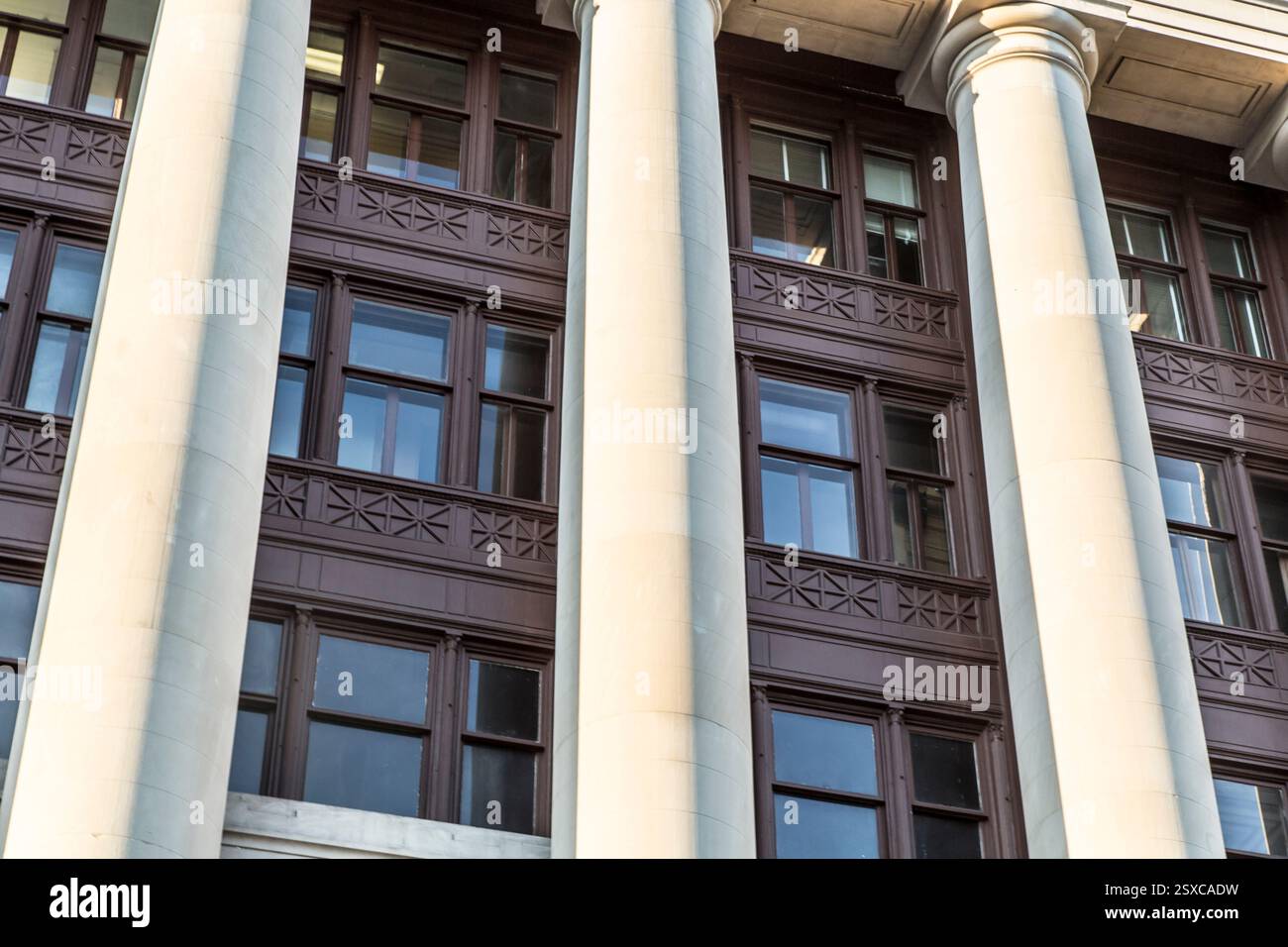 Building with a lot of windows and pillars. The pillars are brown and ...