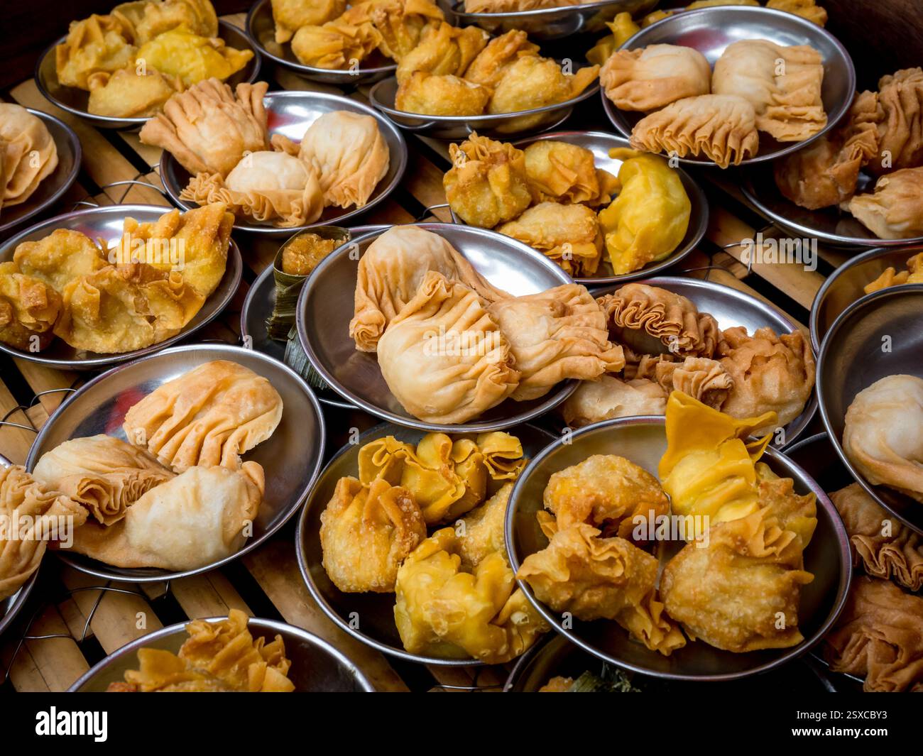 Many oriental crispy deep fried wontons in small stainless steel mini ...
