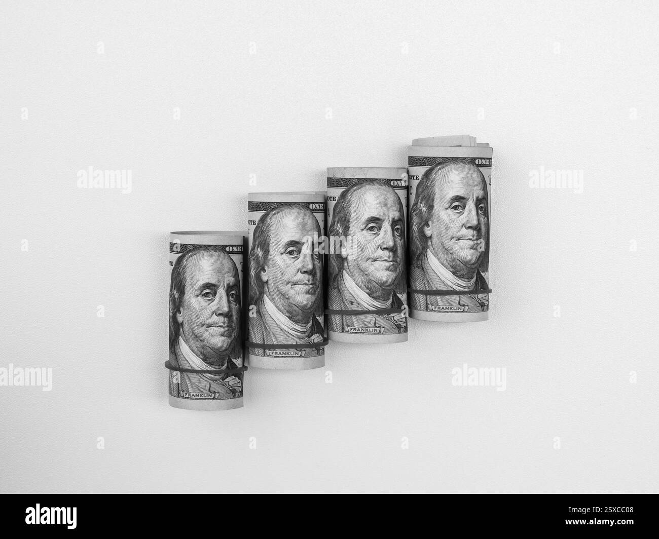Four rolled of one hundred dollars bill banknote, with rubber band ...