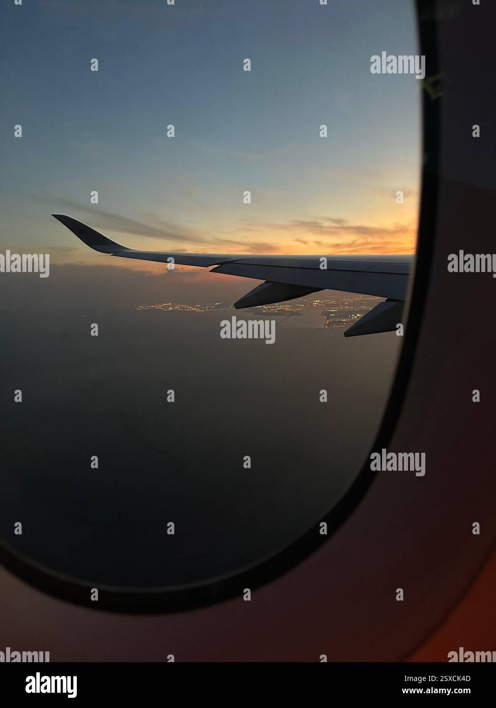 Airplane window view of sunset overlooking Doha, Qatar Stock Photo - Alamy