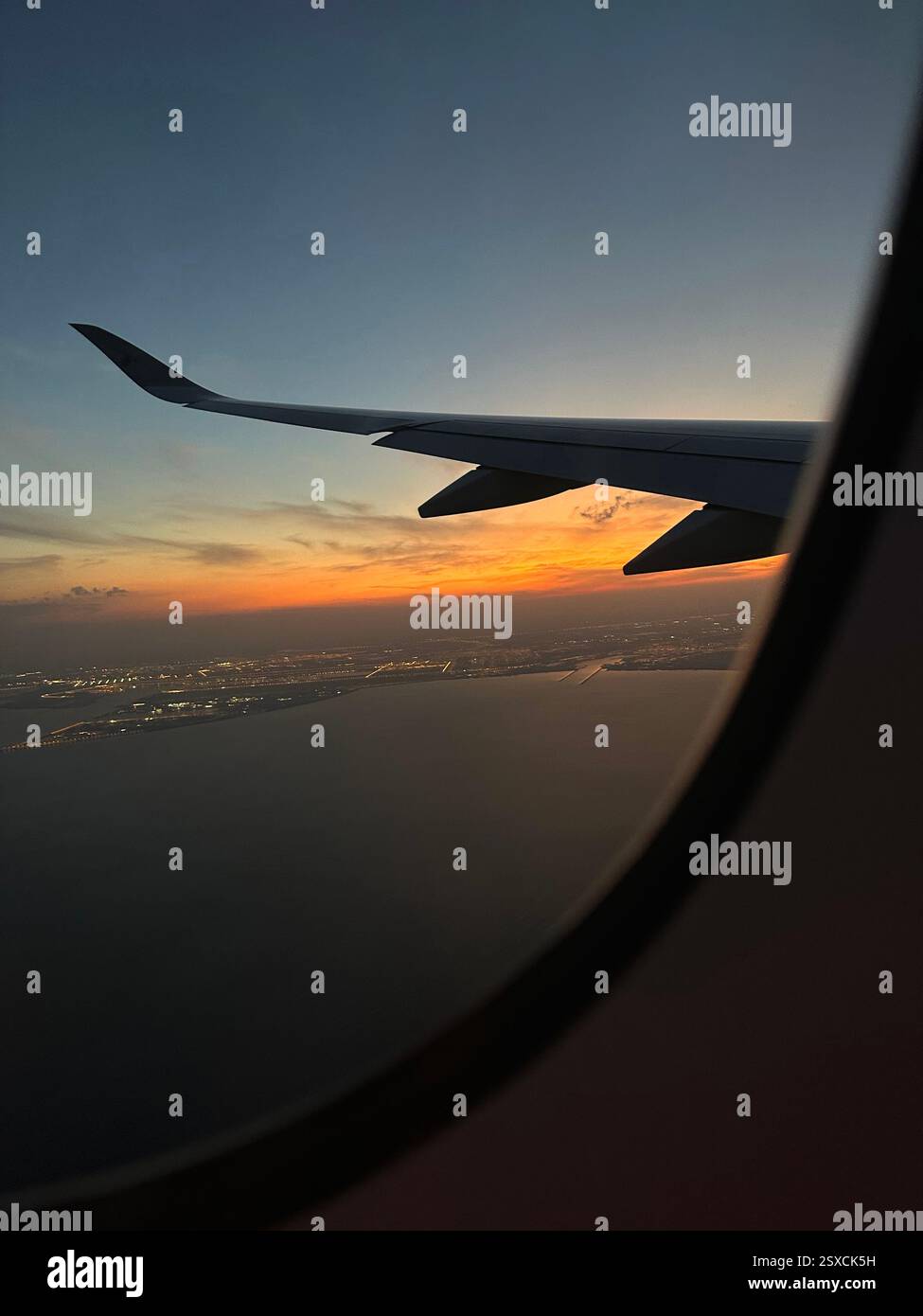 Airplane window view of sunset overlooking Doha, Qatar Stock Photo - Alamy