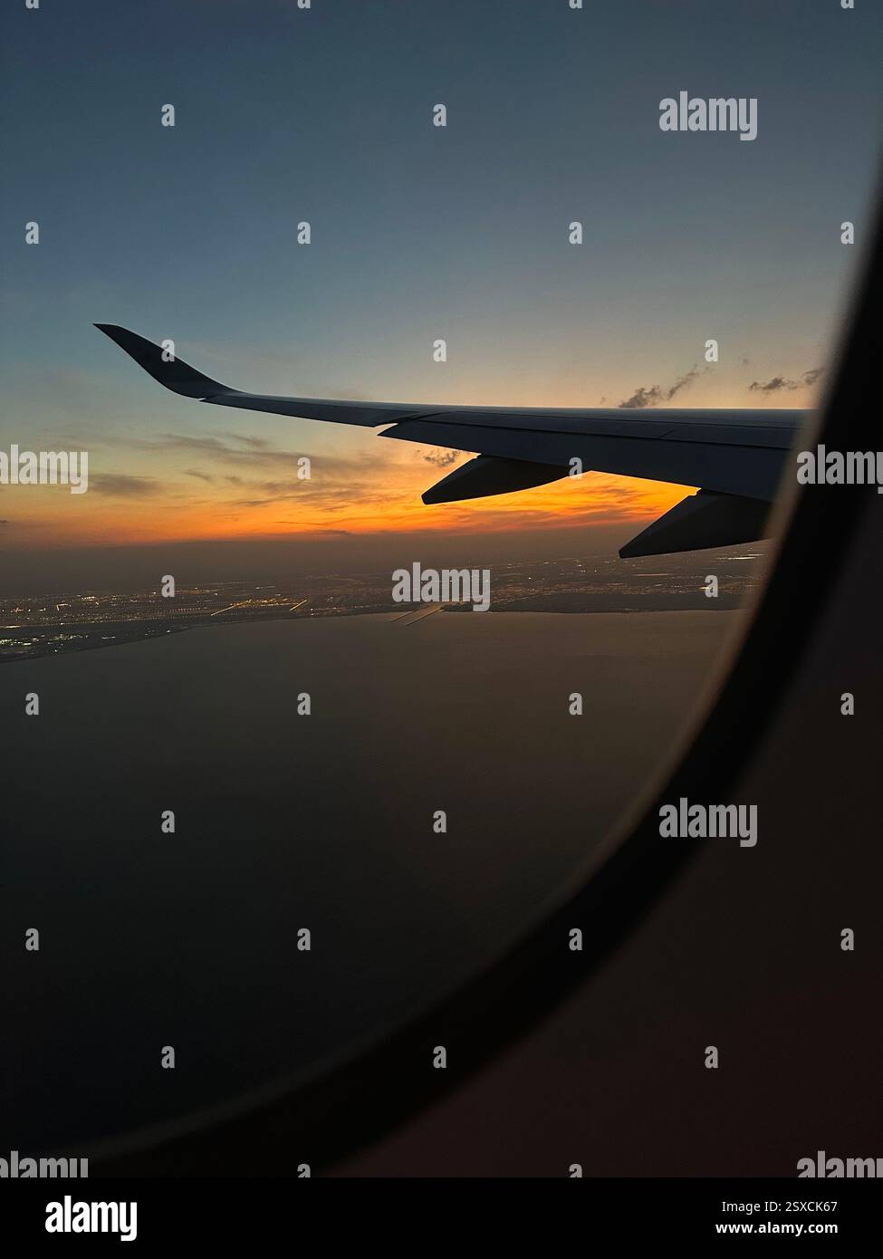 Airplane window view of sunset overlooking Doha, Qatar Stock Photo - Alamy