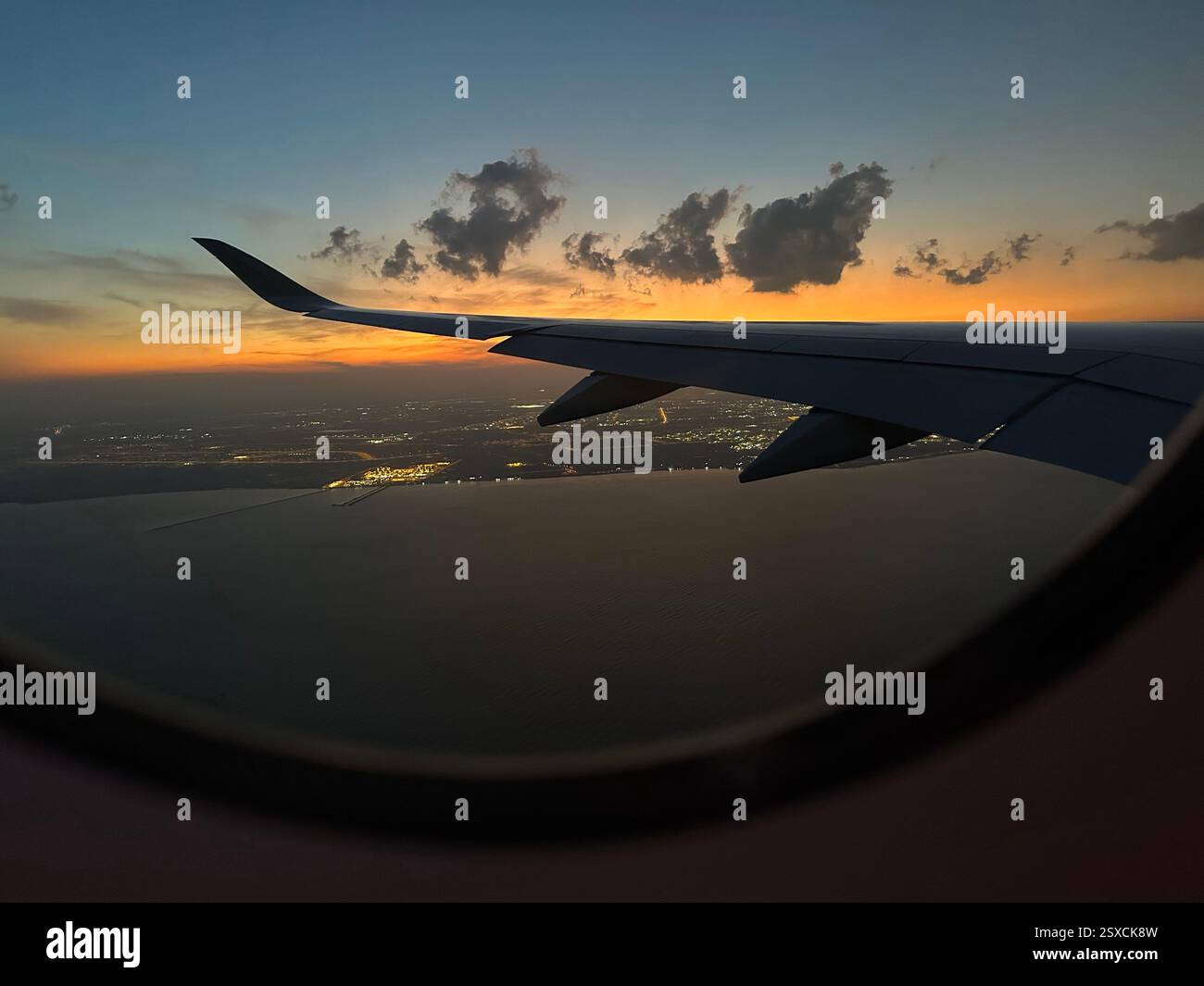 Airplane window view of sunset overlooking Doha, Qatar Stock Photo - Alamy