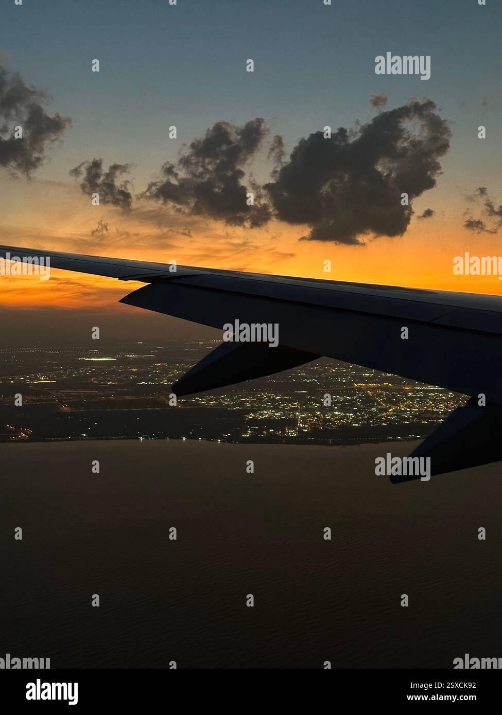 Airplane window view of sunset overlooking Doha, Qatar Stock Photo - Alamy