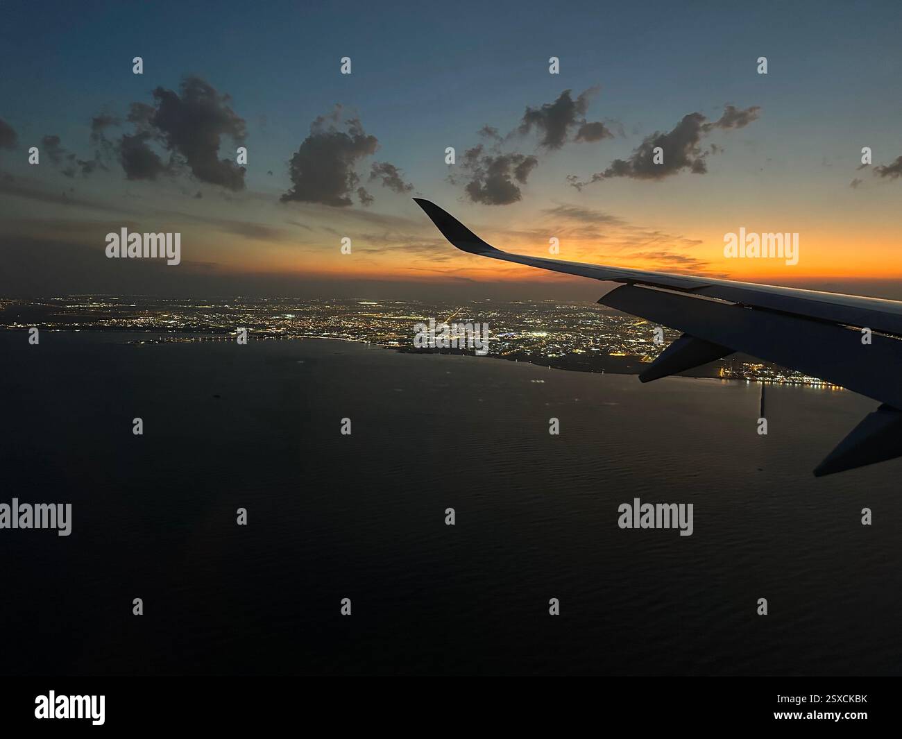 Airplane window view of sunset overlooking Doha, Qatar Stock Photo - Alamy