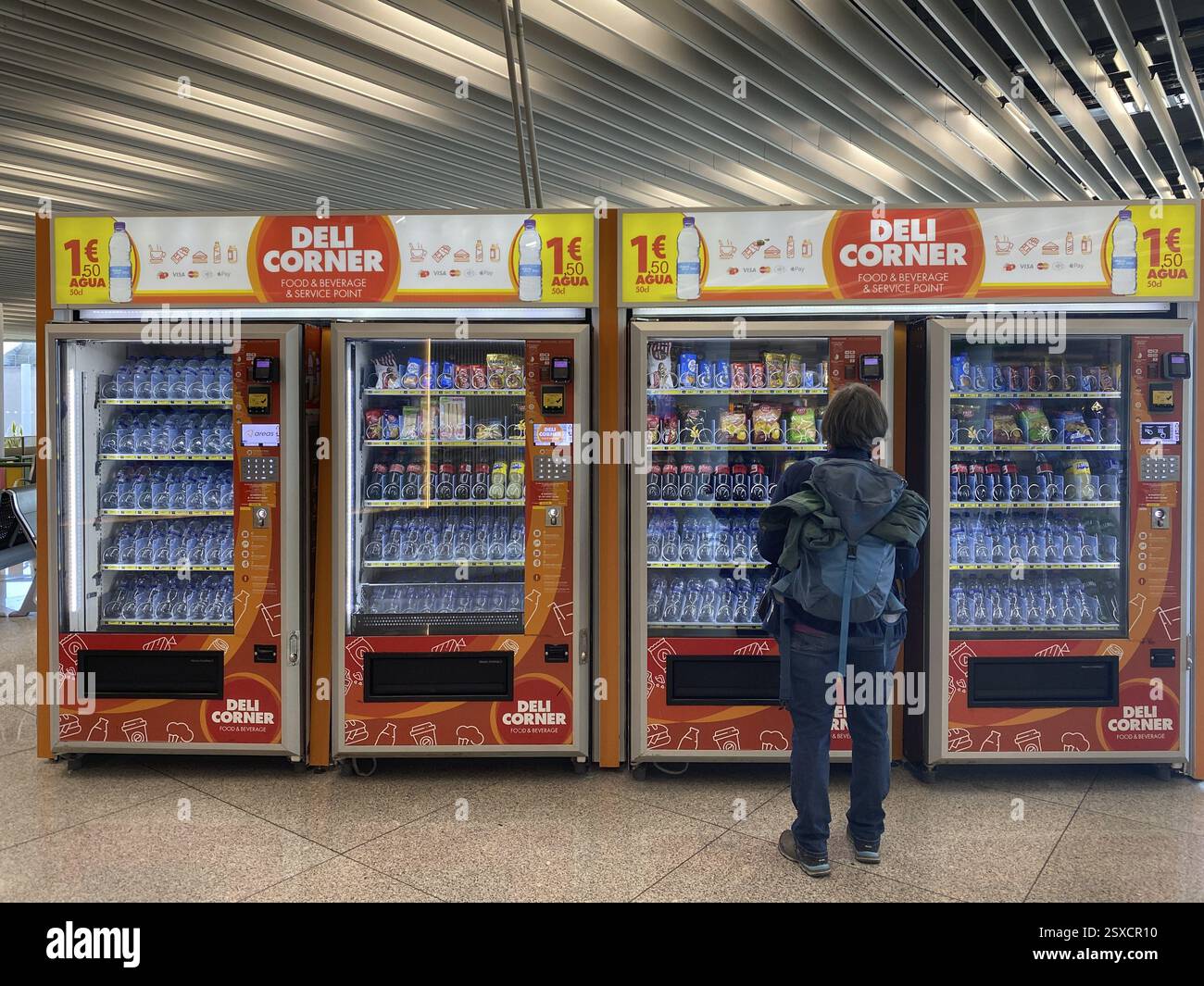 Elderly woman in front of vending machine, interior view, Aeropuerto de ...
