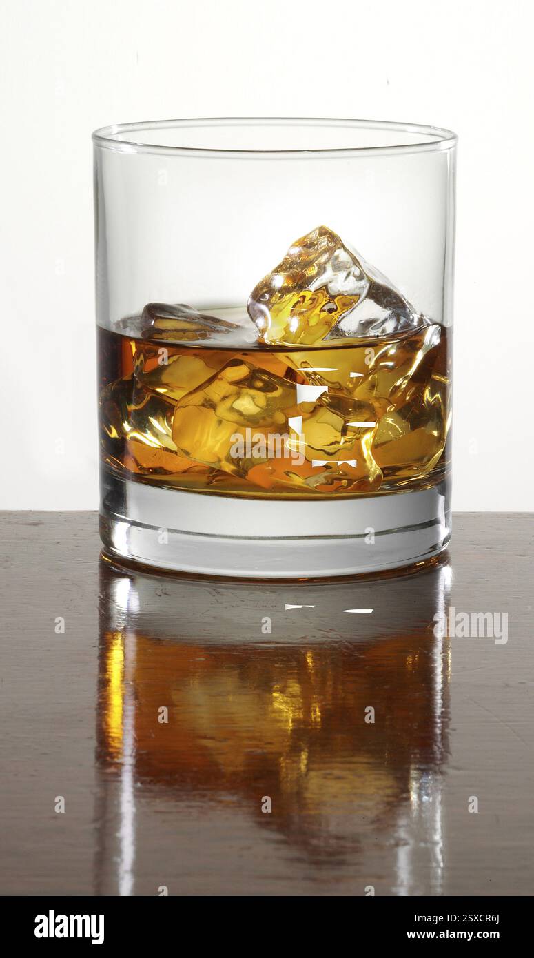 Whisky neat on ice cube cubes in a tumbler on a bar counter, studio ...