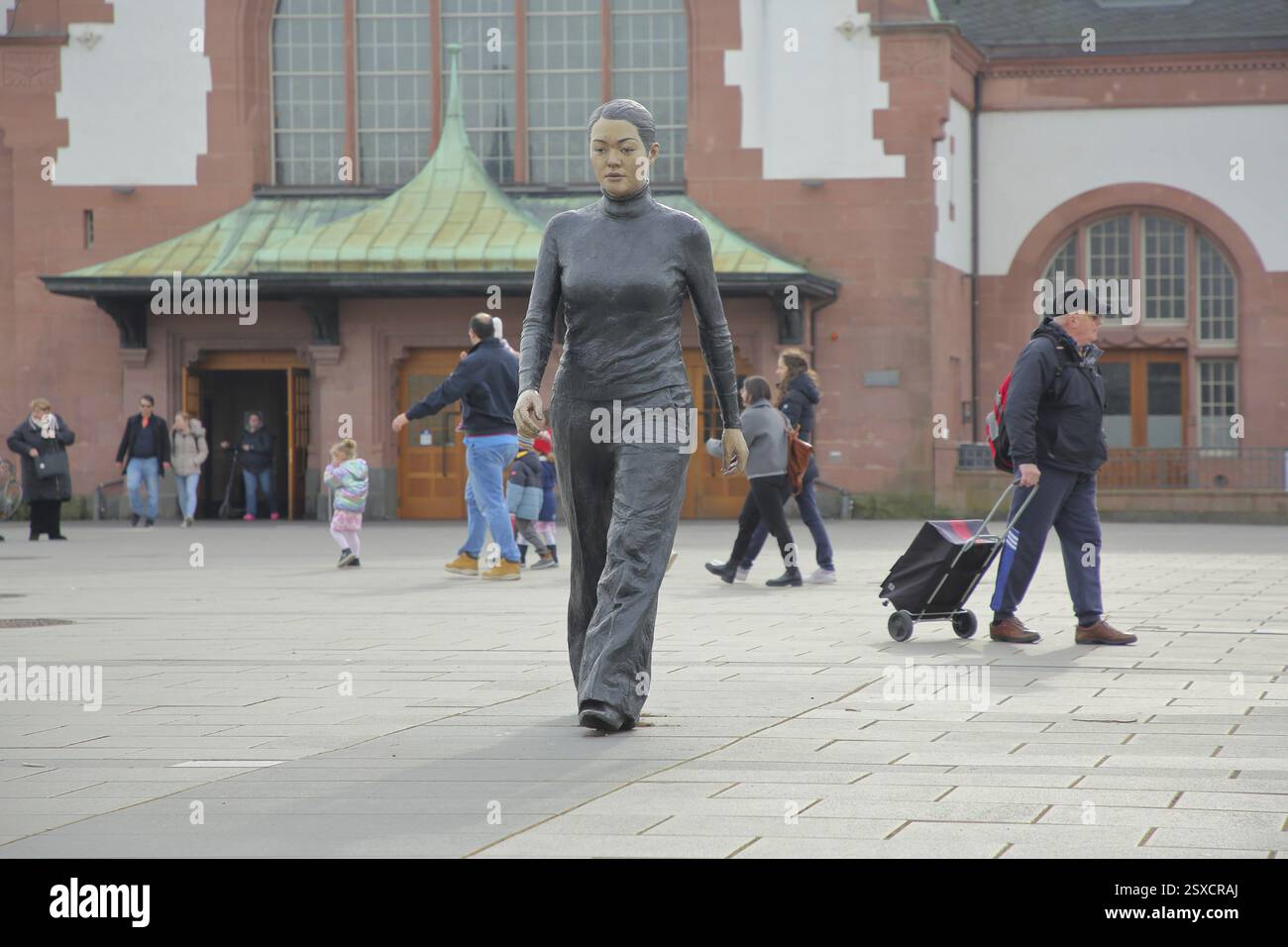 Sculpture Walking Woman by Sean Henry 2013 and many passengers and ...