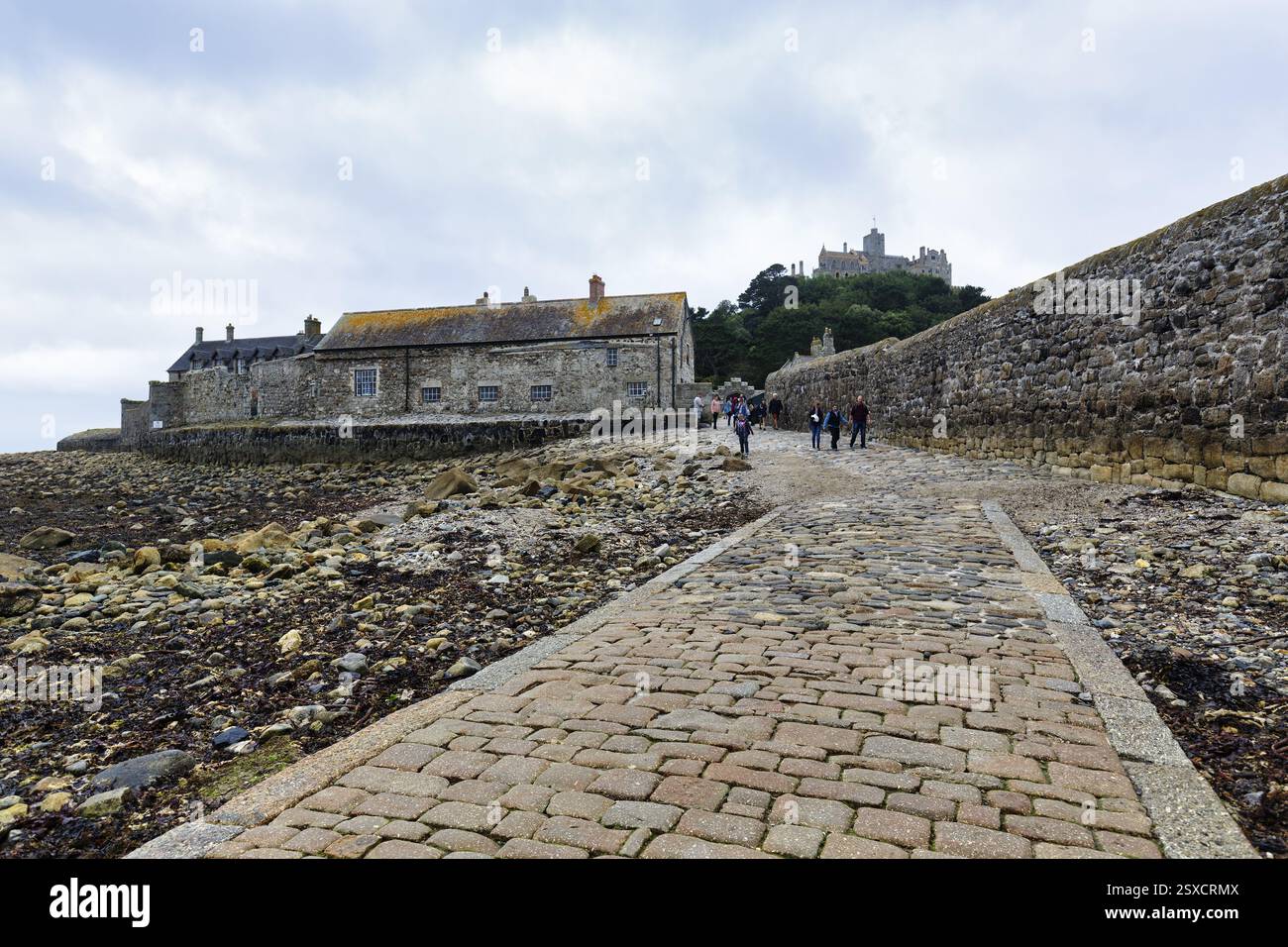 Walkers, cobbled causeway, St Michael's Mount, tidal island with castle ...