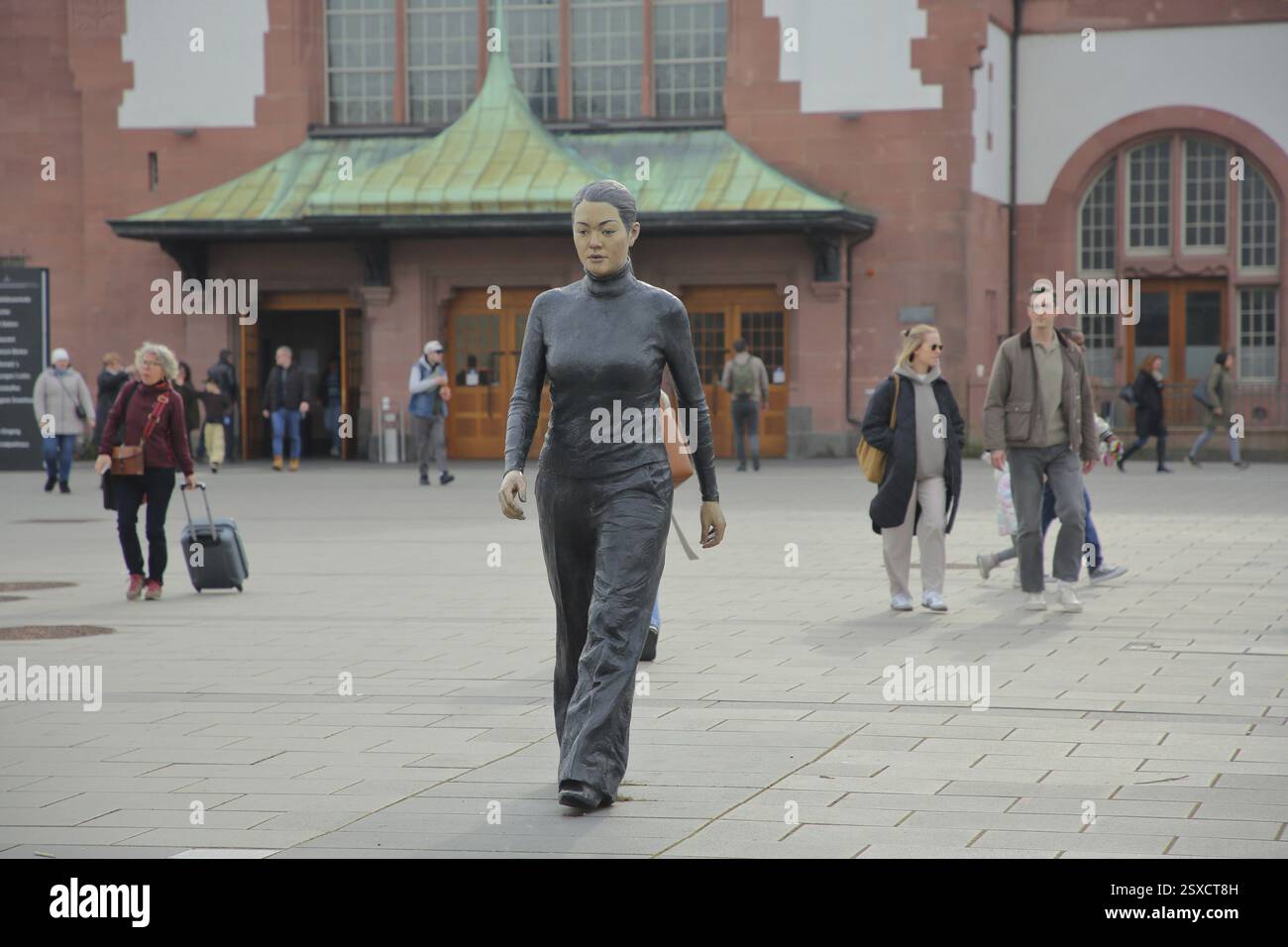 Sculpture Walking Woman by Sean Henry 2013 and many passengers and ...