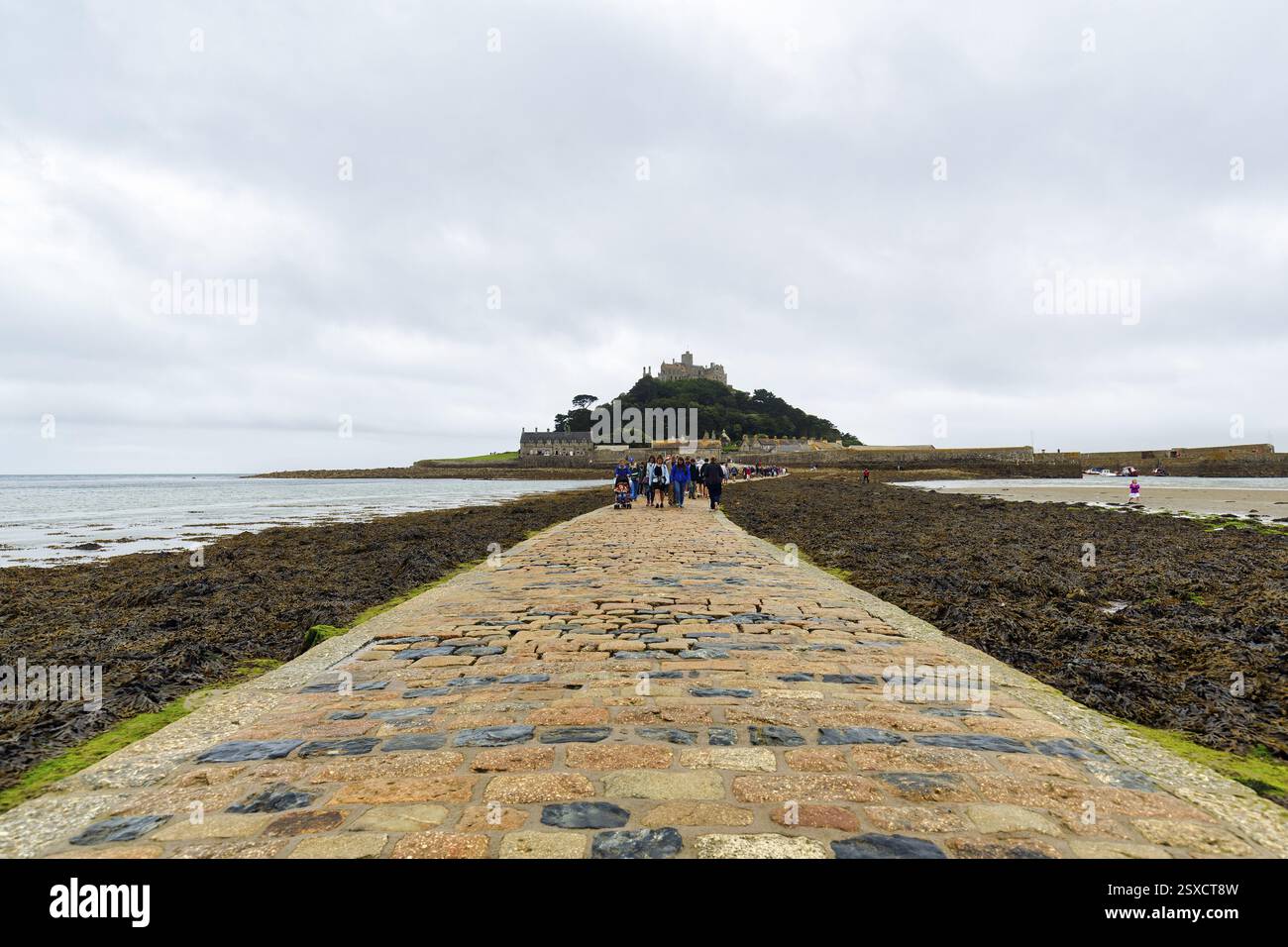 Walkers, cobbled causeway, St Michael's Mount, tidal island with castle ...