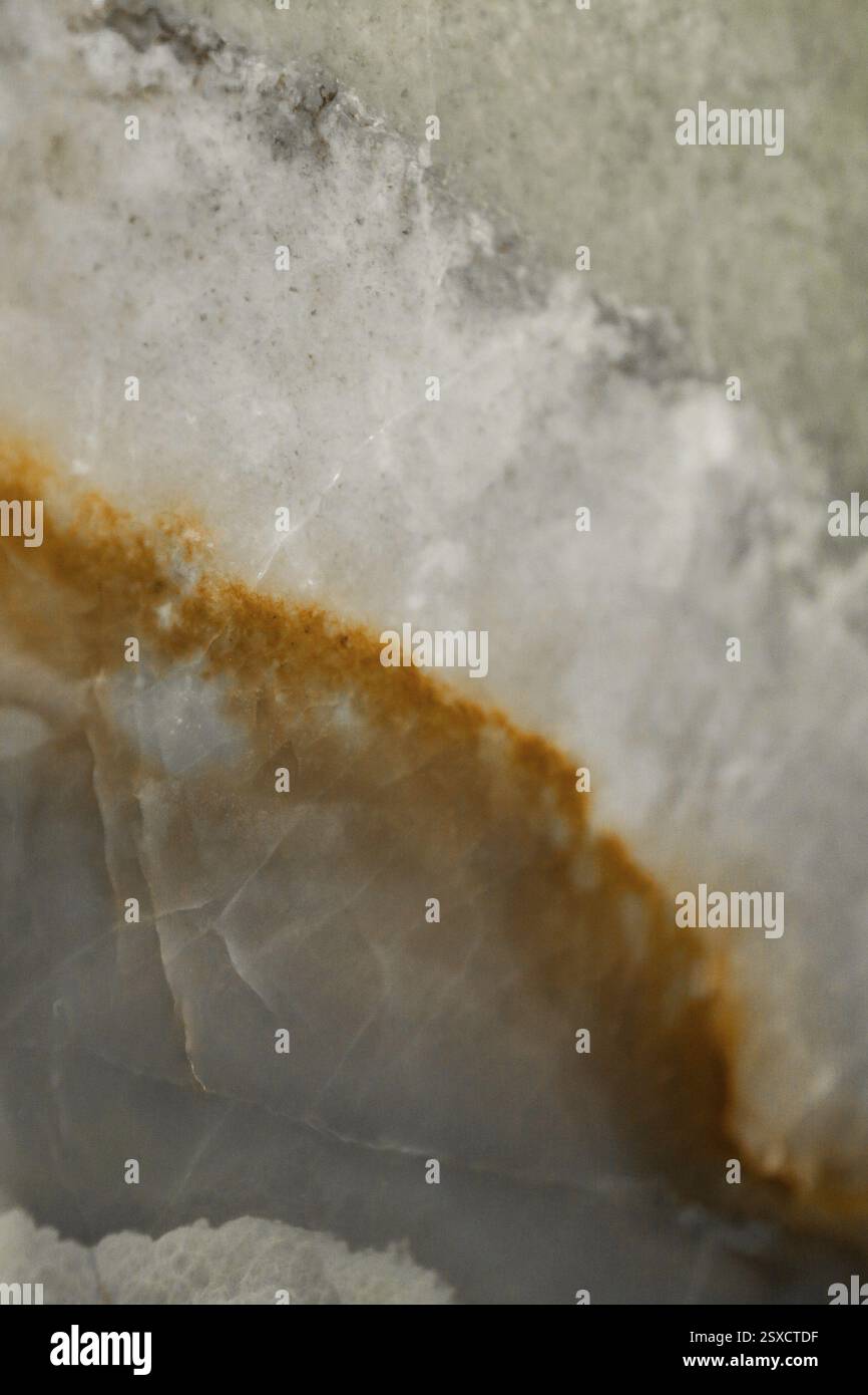 Close-up of marble showing a distinct orange vein and gray texture ...