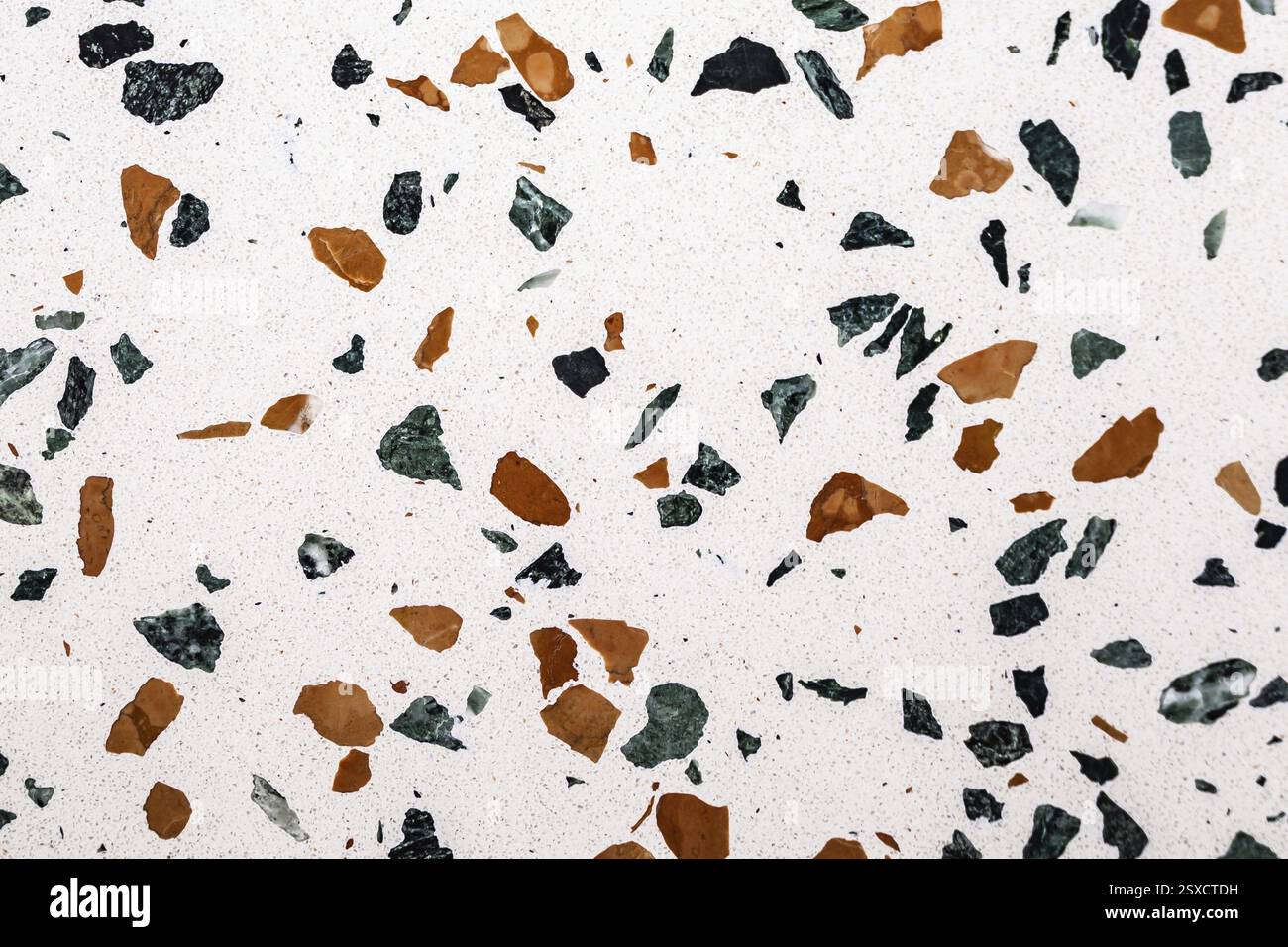 White terrazzo surface with green and brown speckles forming a distinct ...